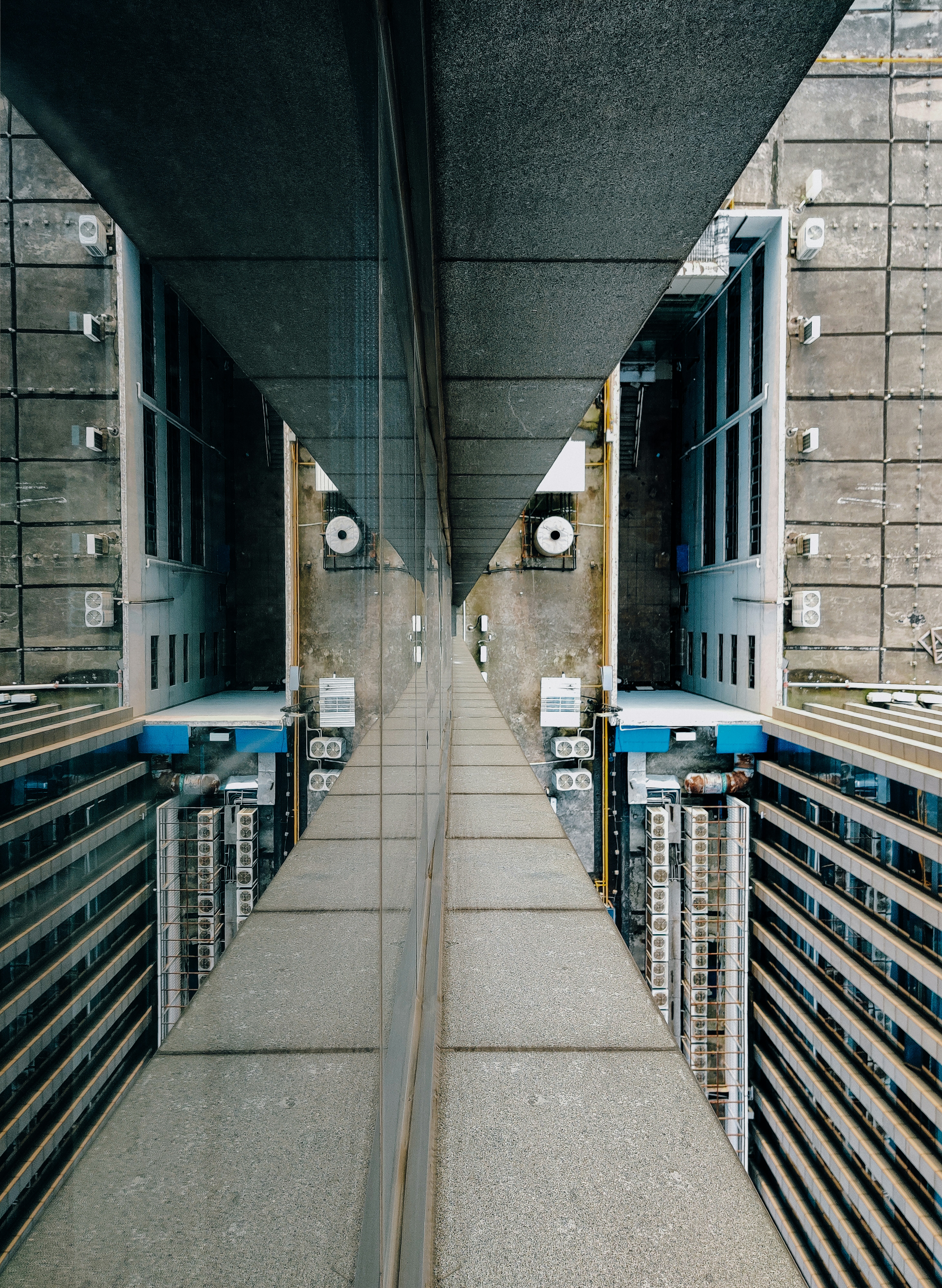 A reflective view of a high-rise building's facade, showcasing the intricate patterns of windows and air conditioning units below.