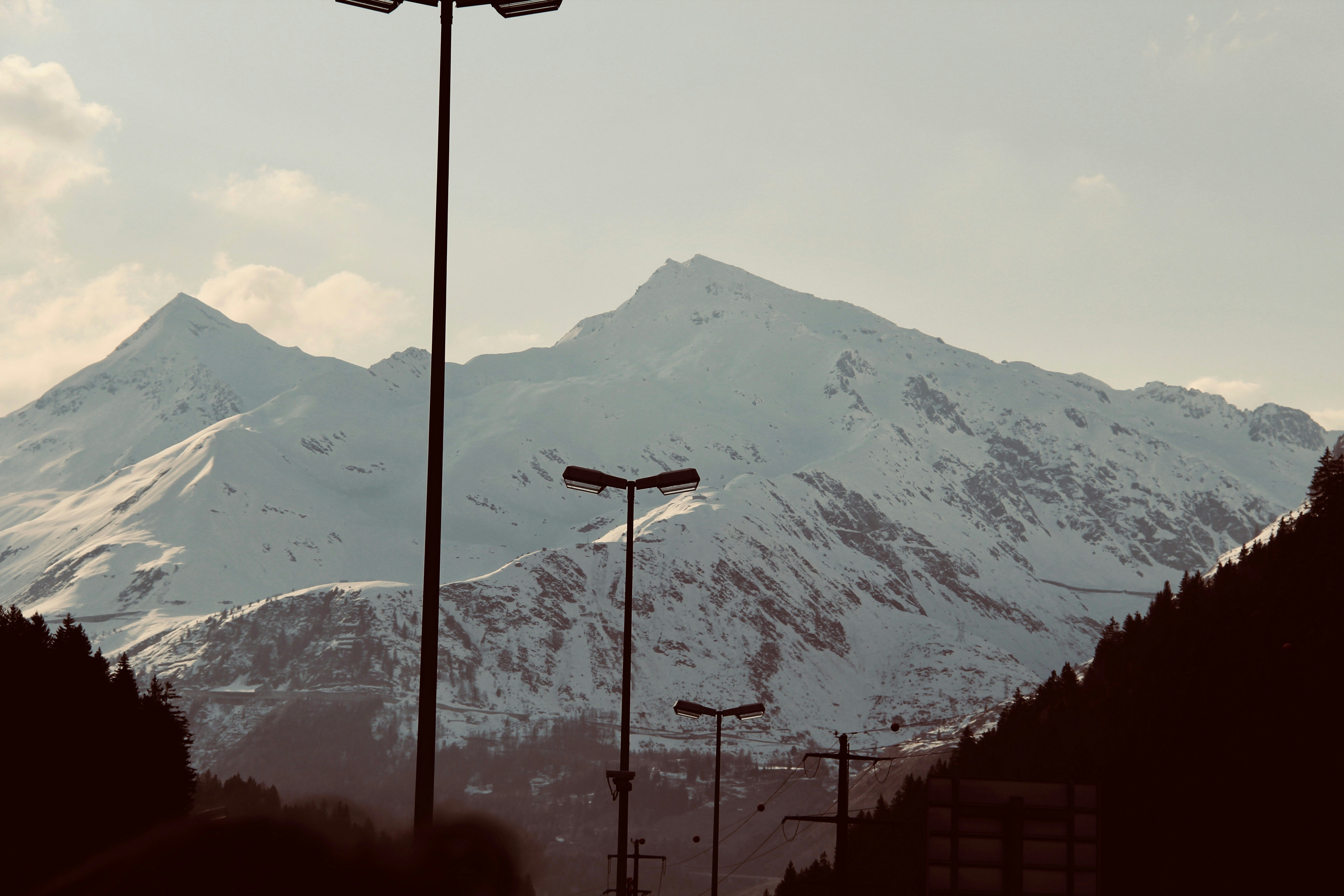 Alpine Summit Framed by a Line of Streetlights