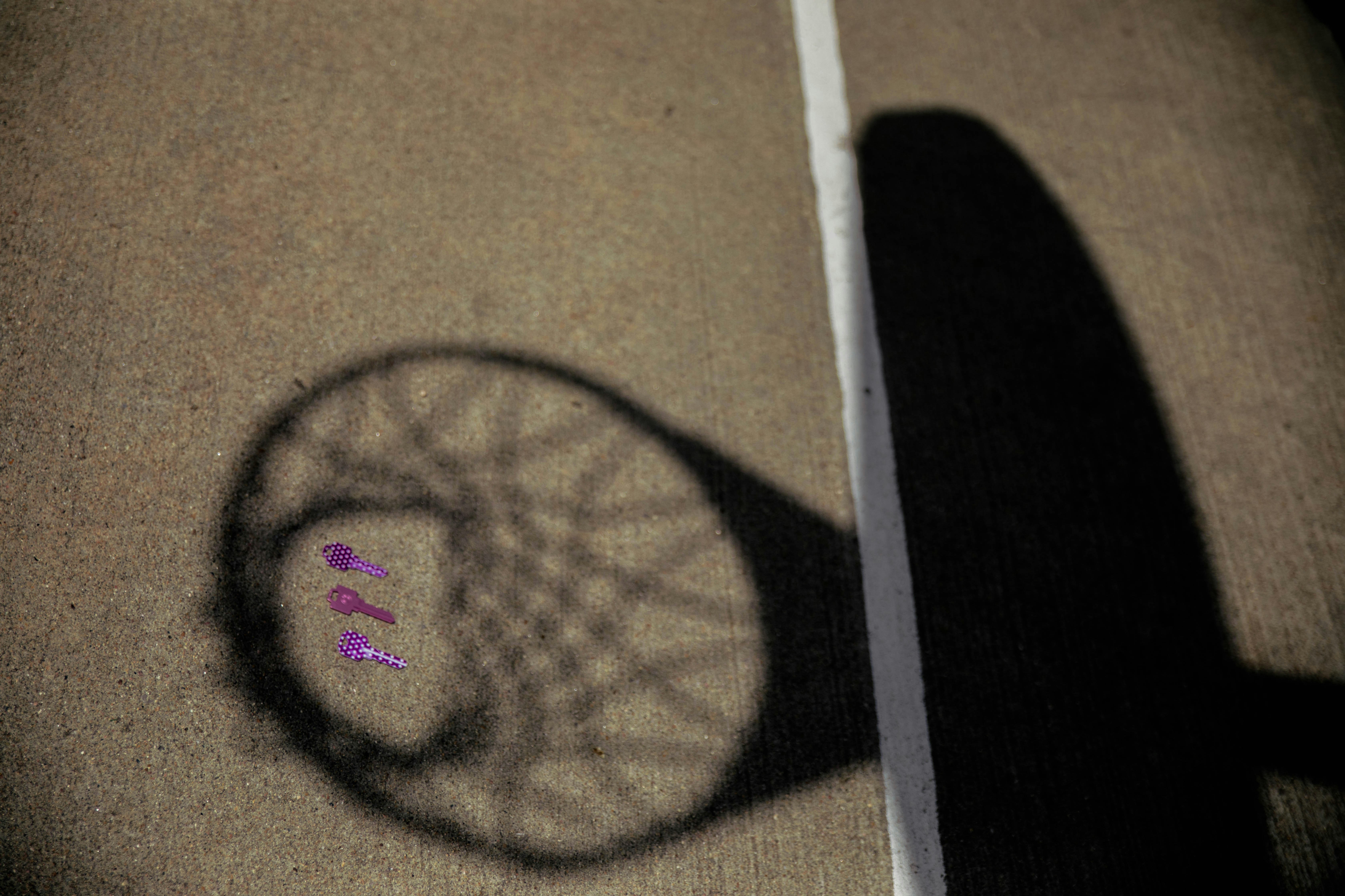 Shadow of a Basketball Hoop Cast on Paved Court