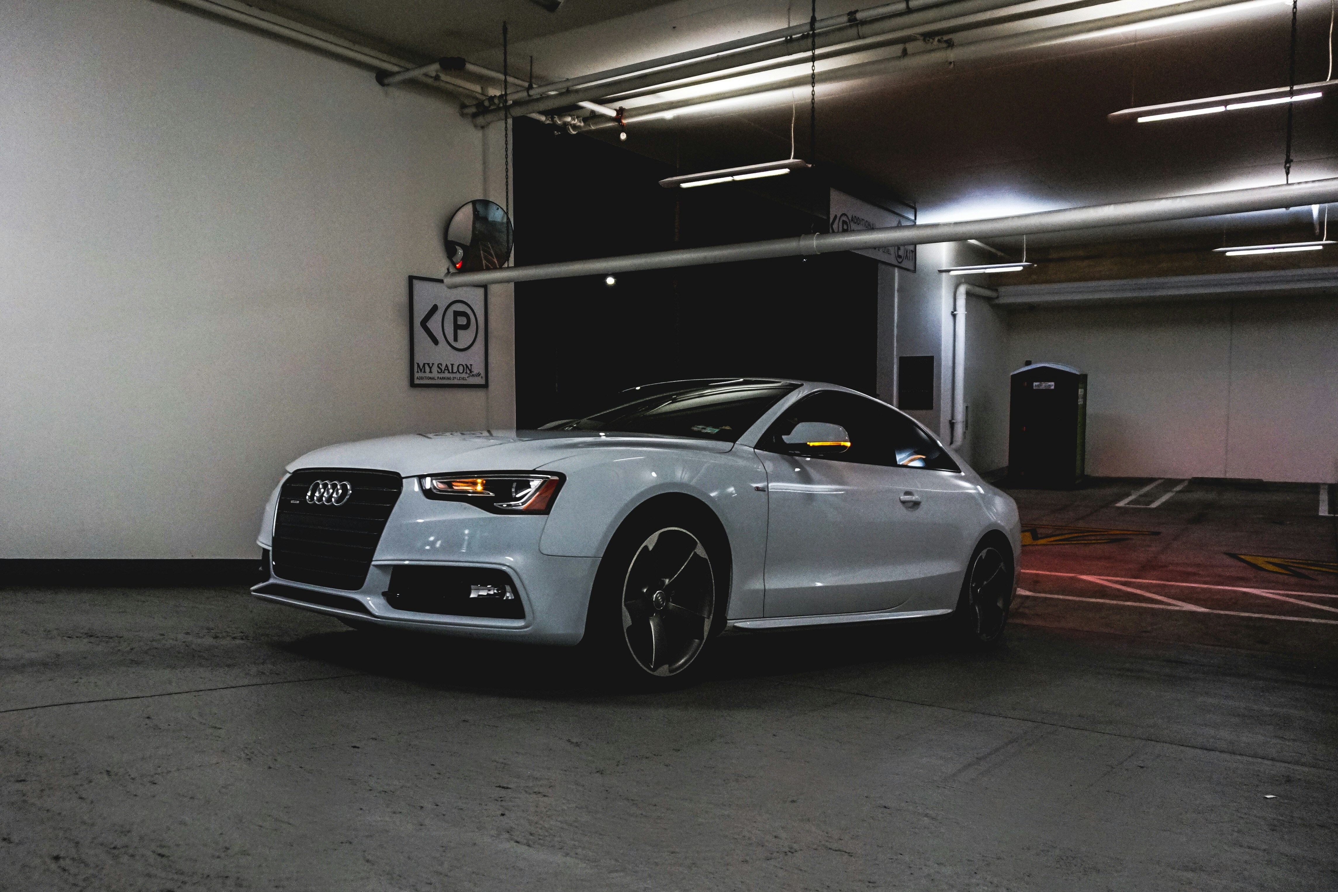 Audi A5 Coupe parked in a dimly lit parking garage, showcasing its sleek design and modern aesthetics.