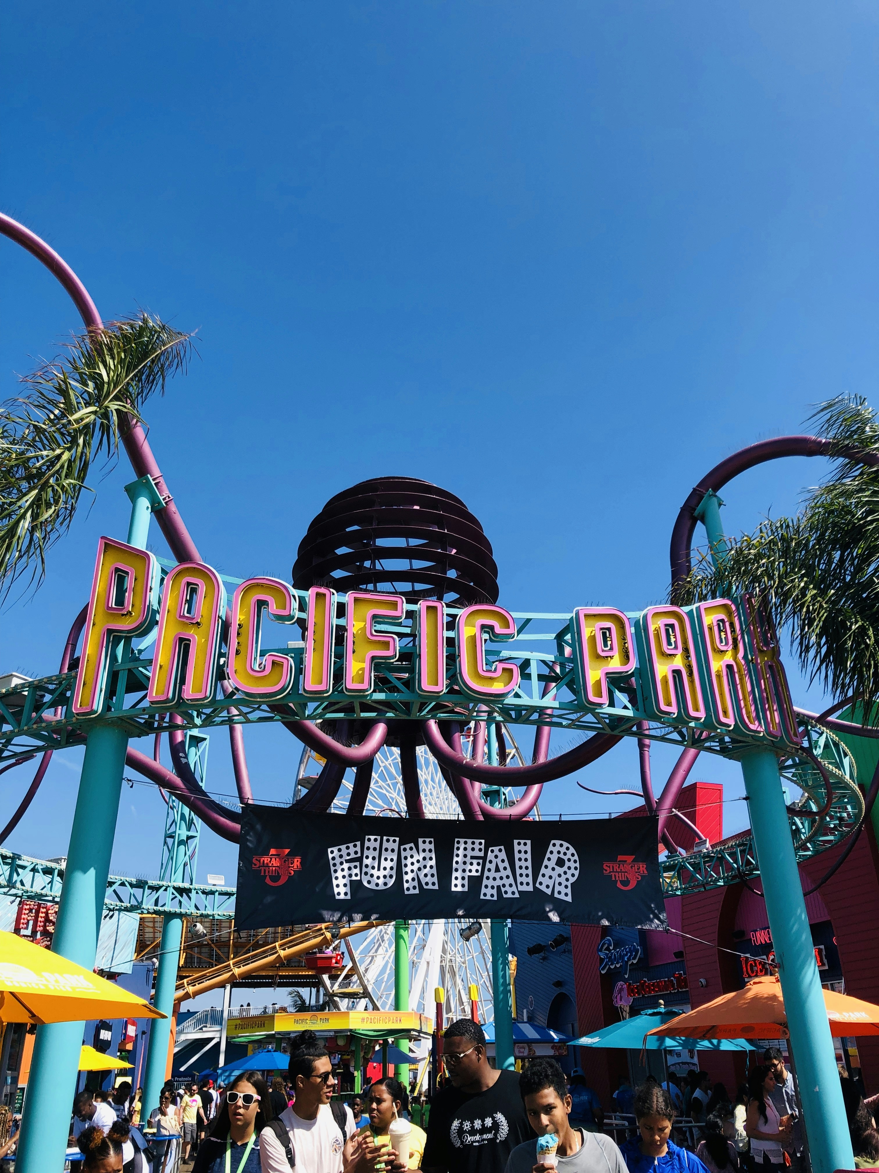 Neon Gateway to Pacific Park Under a Clear Blue Sky