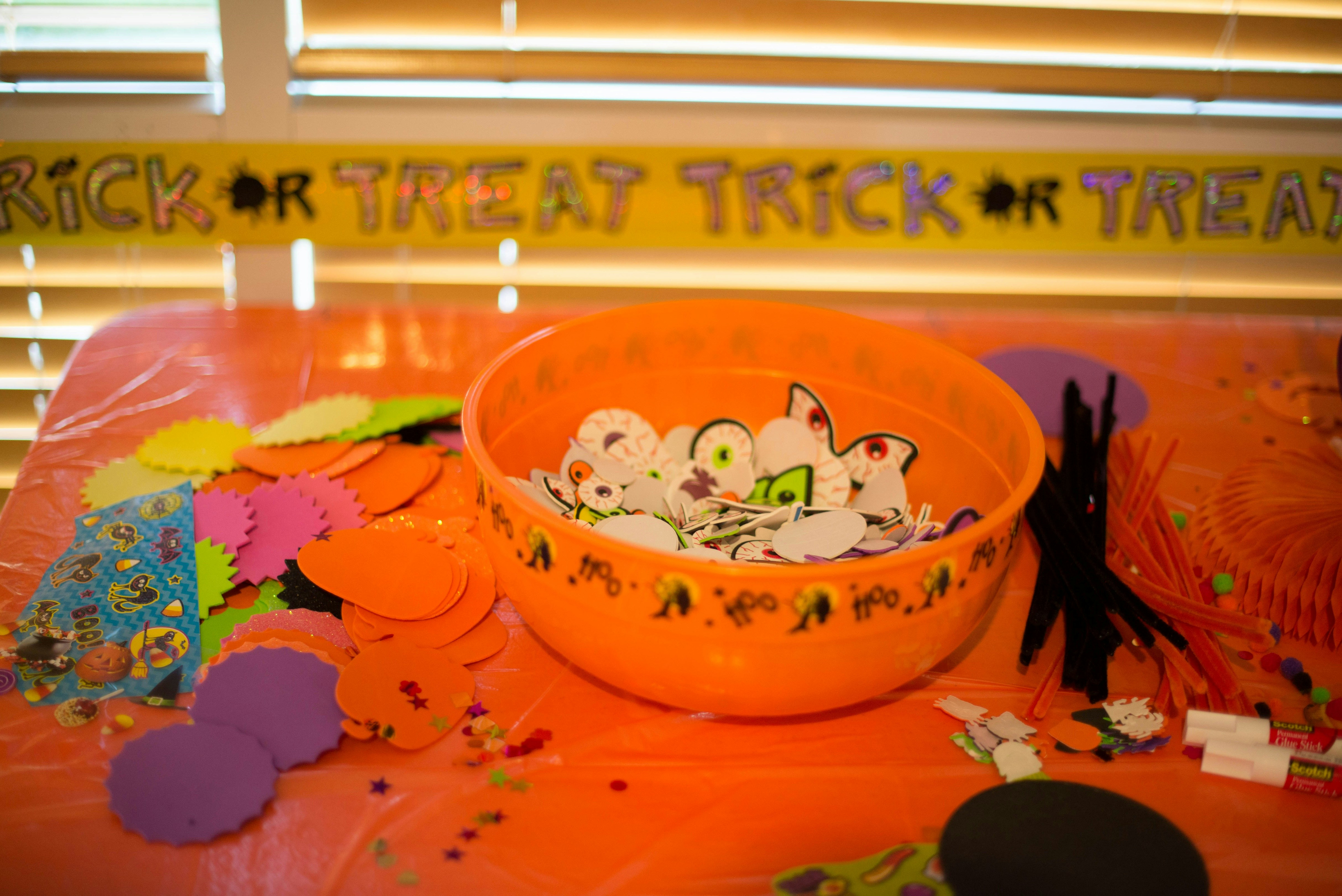 Centerpiece Orange Bowl: Cat Motifs Amid Confetti on a Trick-or-Treat Table