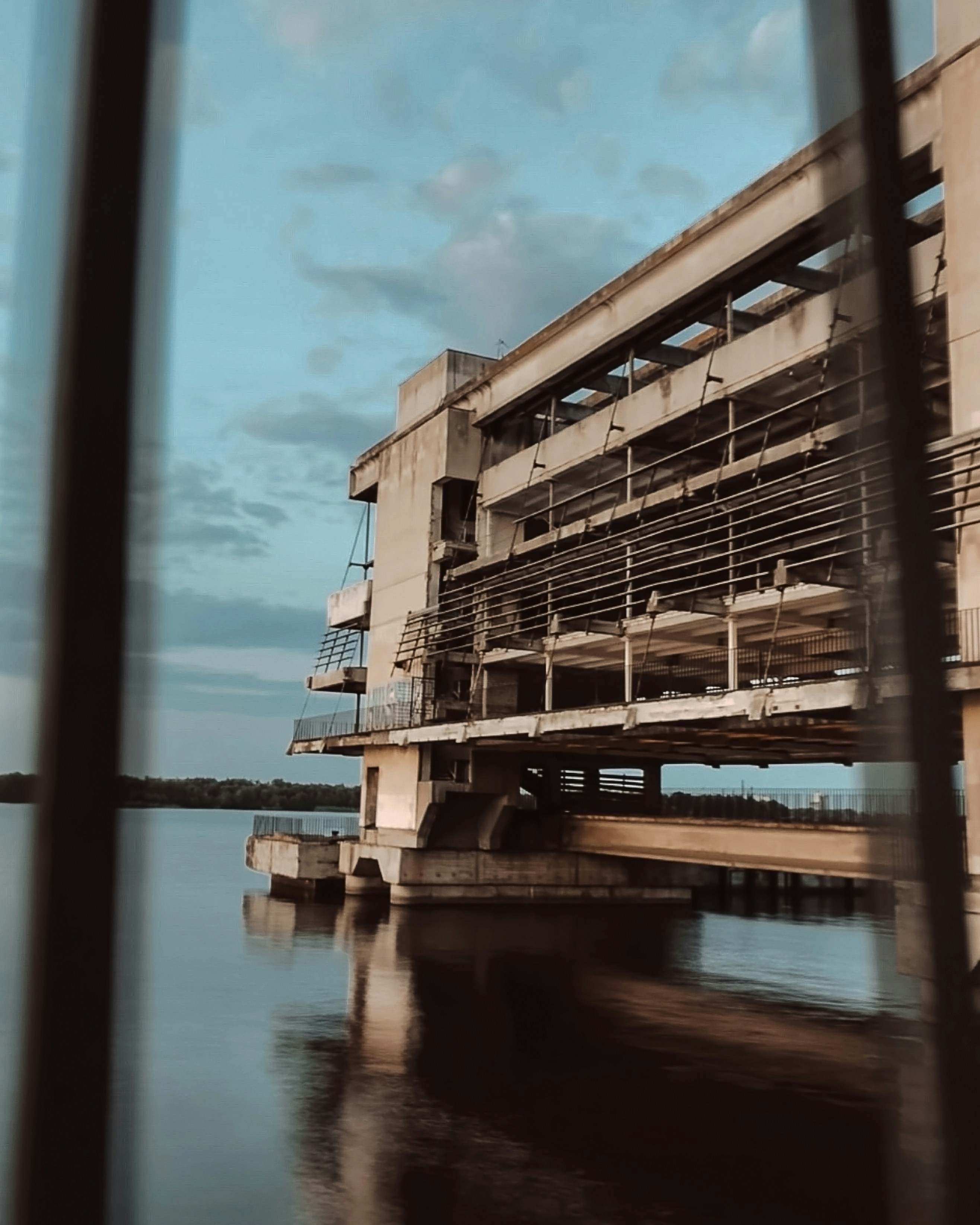Echoes of Steel and Sky: A Waterfront Brutalist Structure Framed by Water
