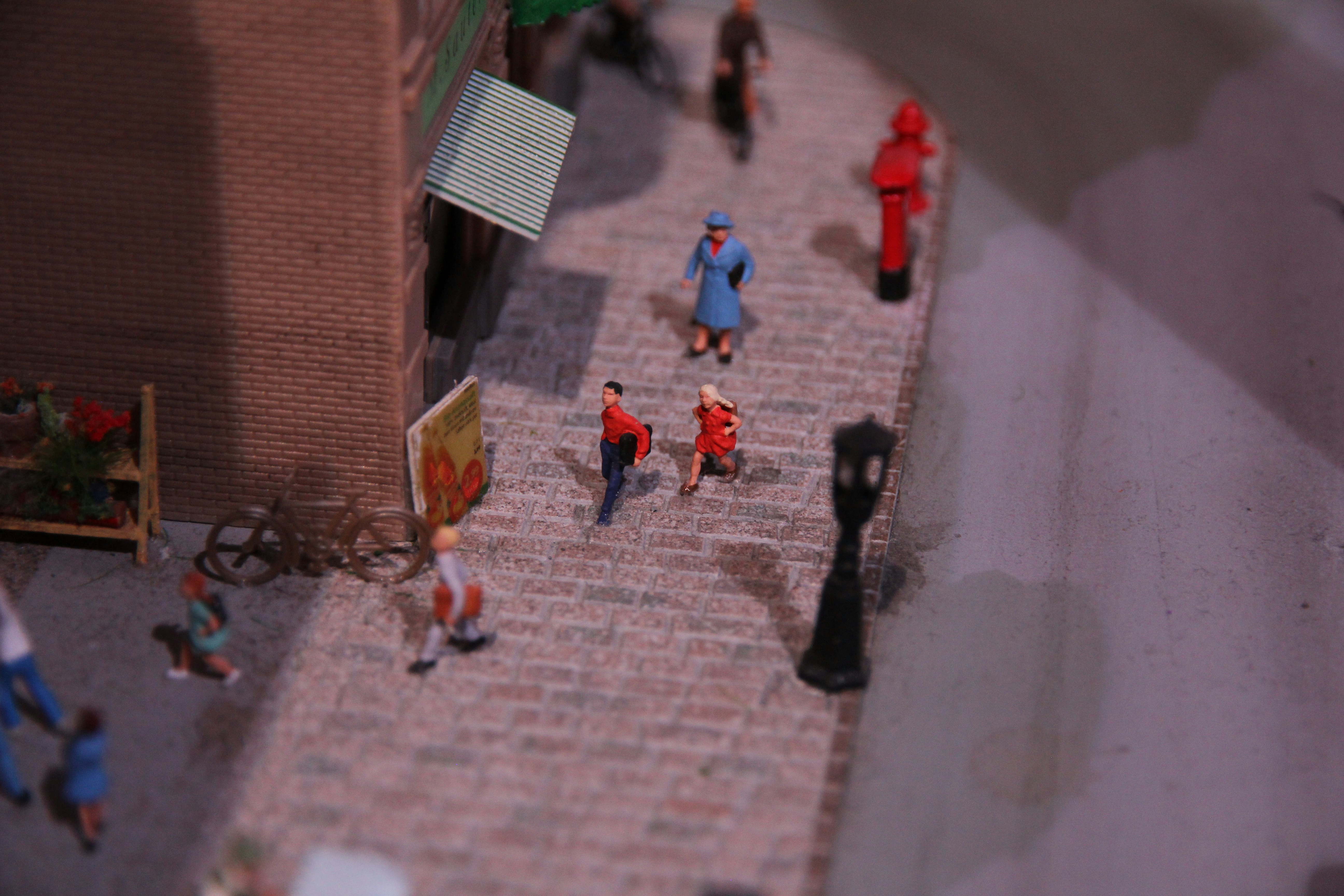 Miniature Street Scene: Tiny Figures on a Cobblestone Walk