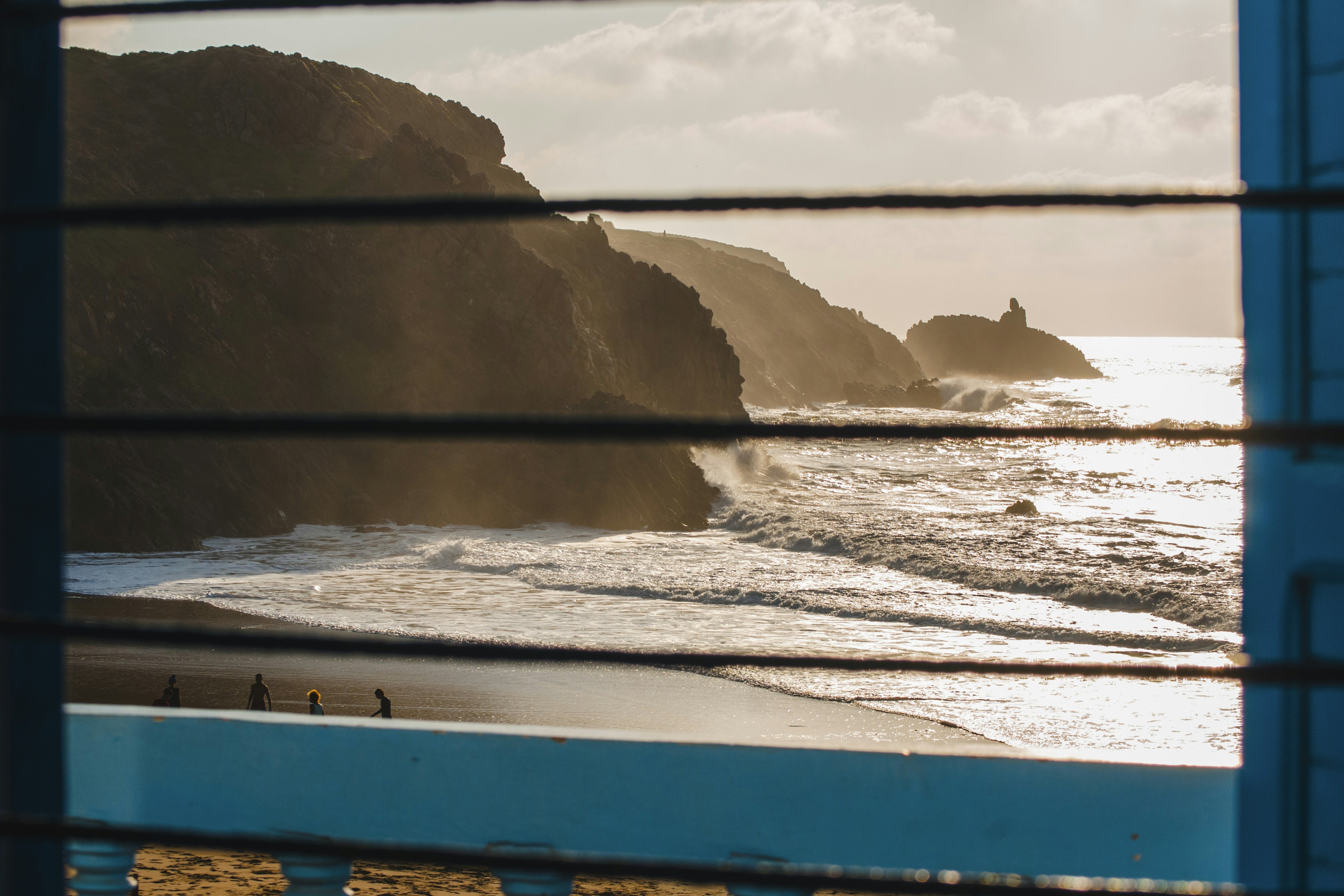 Blue Slats Framing a Distant Sea Stack at Dusk