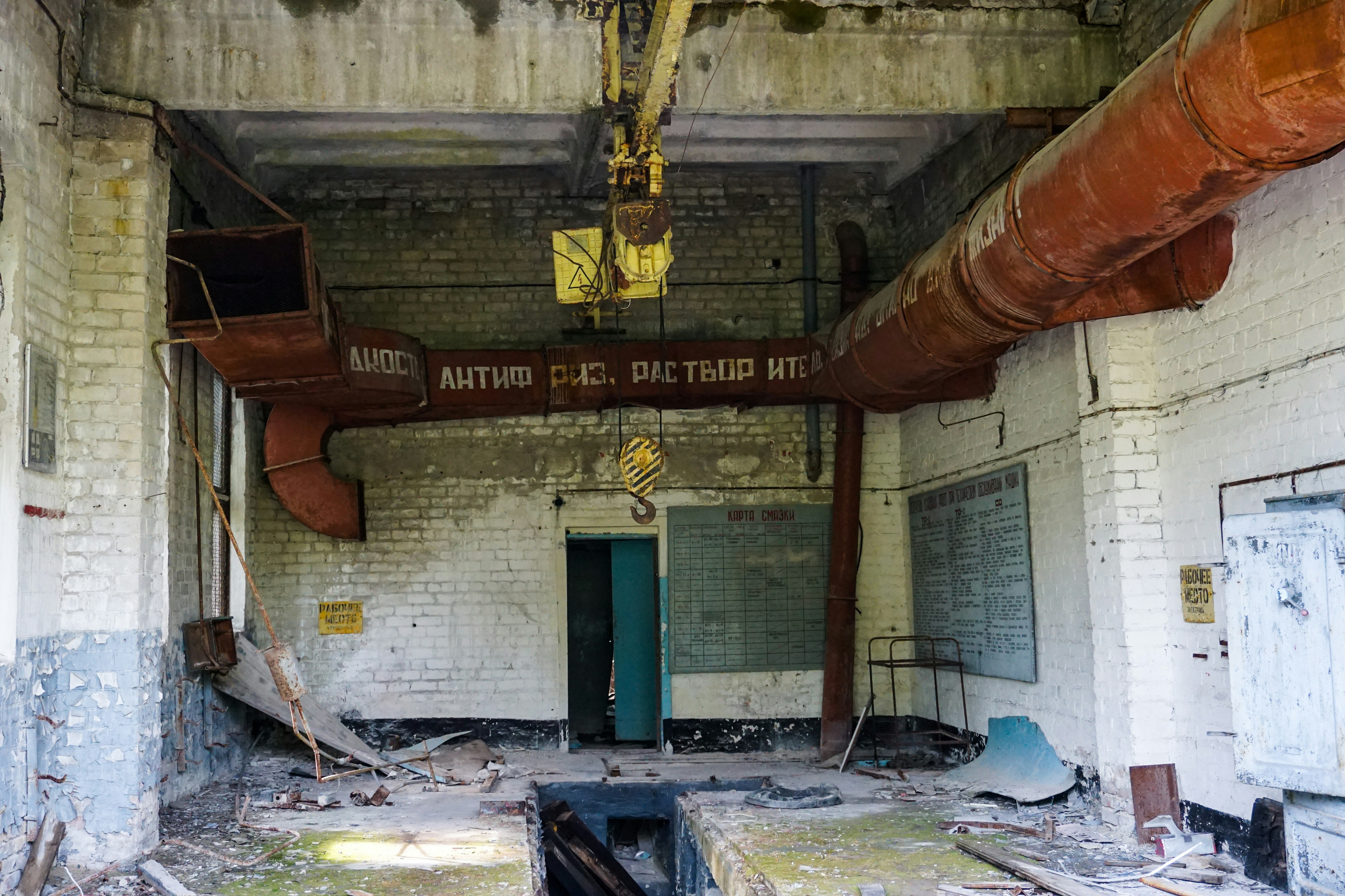 Rusted Threshold: An Abandoned Factory Hall Framed by a Central Door