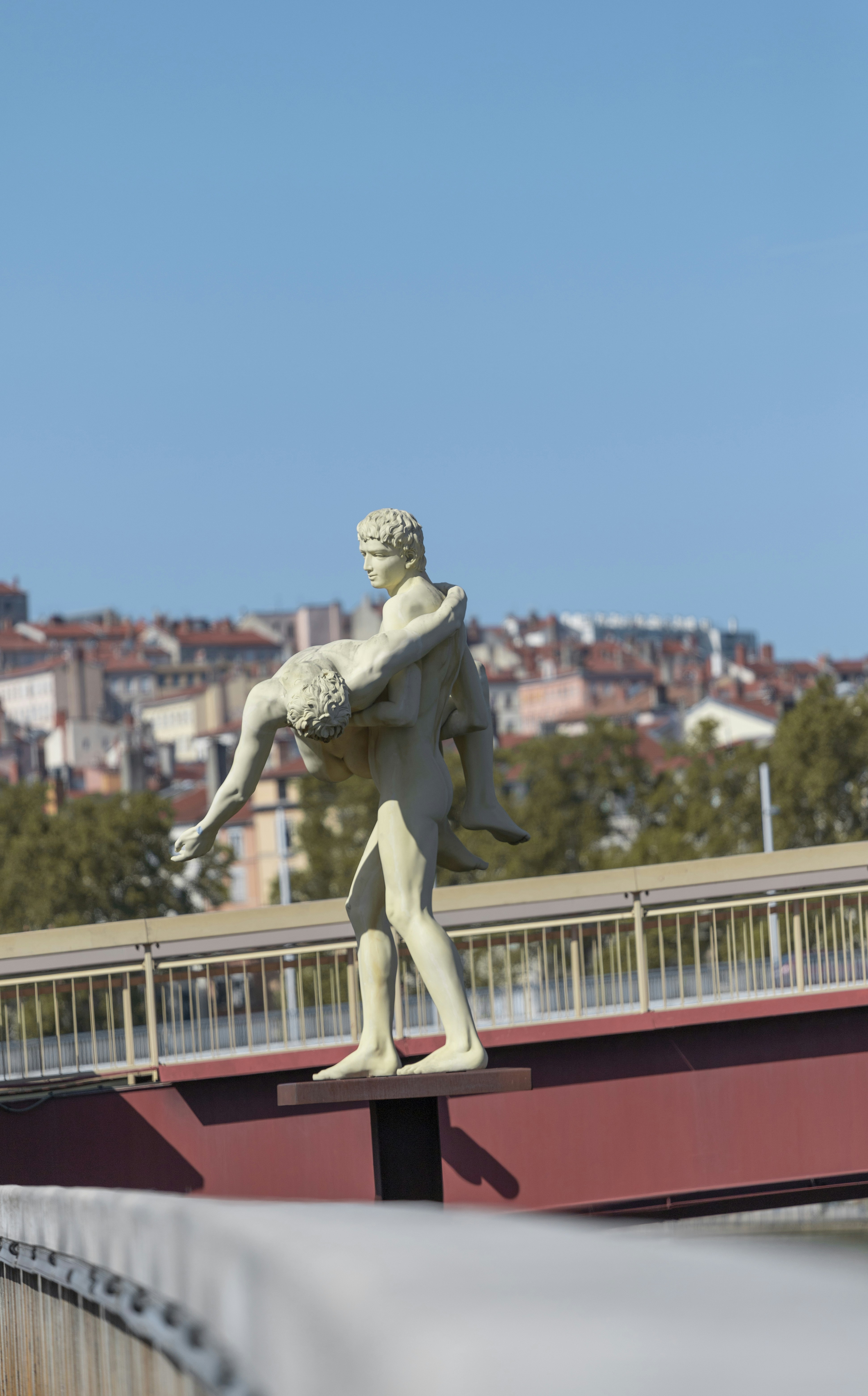 The Lift: Statues on a Cable-Bridge Over a Cityscape