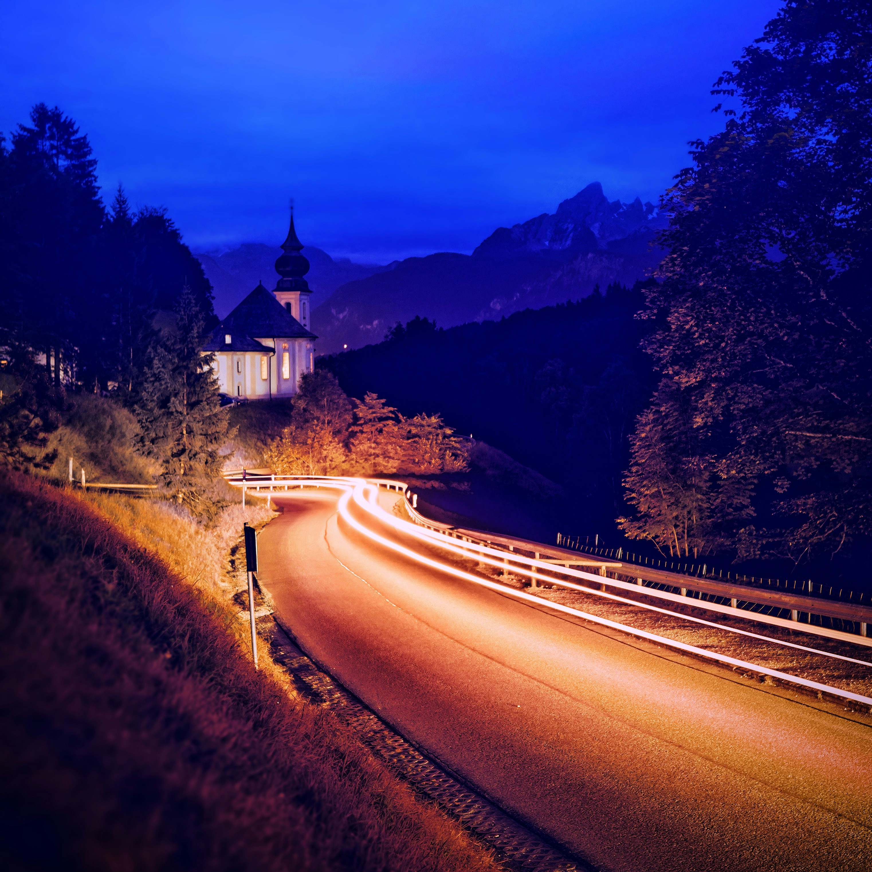 Curved Highway to a Quiet Alpine Church at Blue Hour