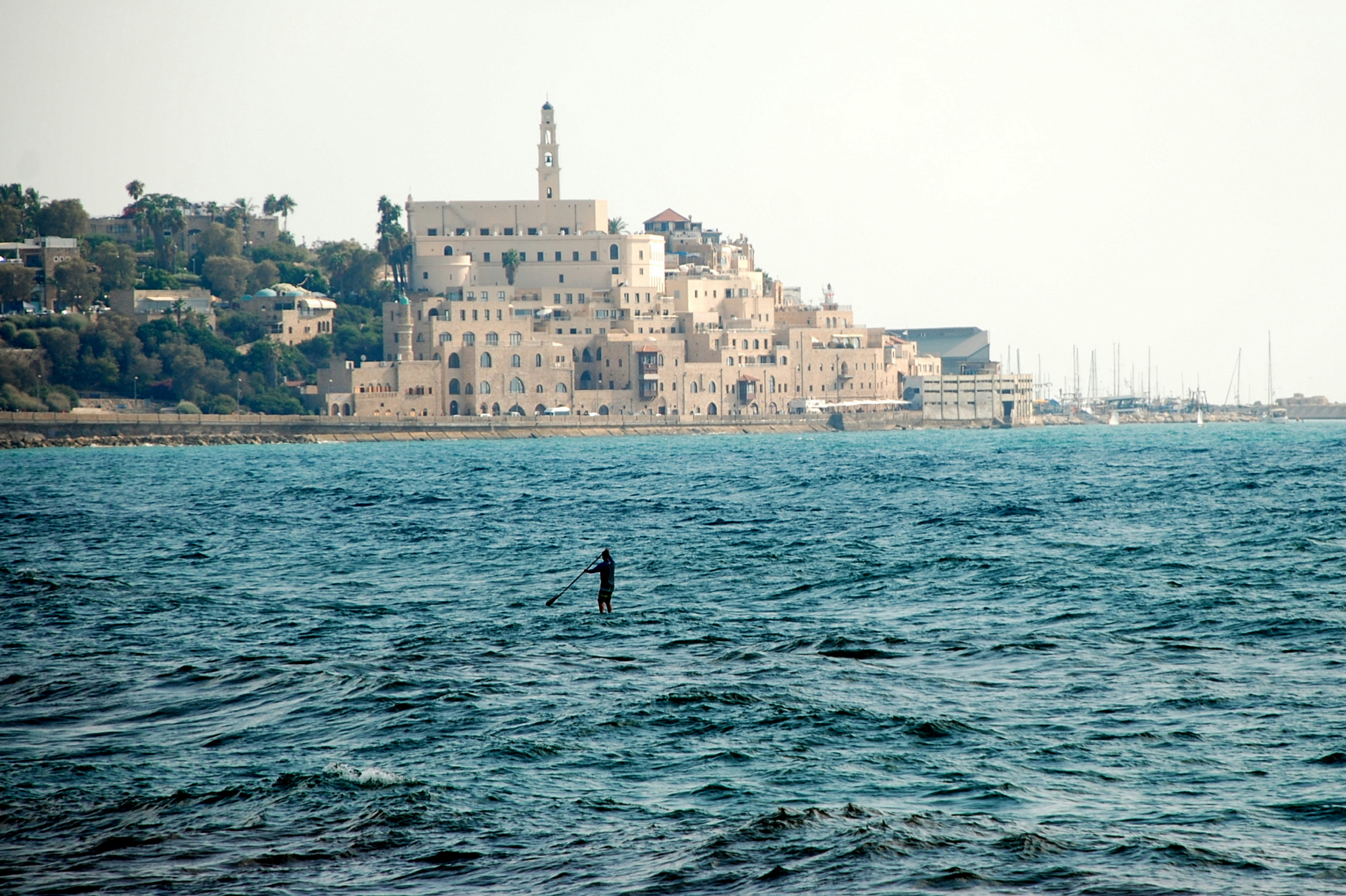 Lone Paddleboarder Before a Limestone Fortress