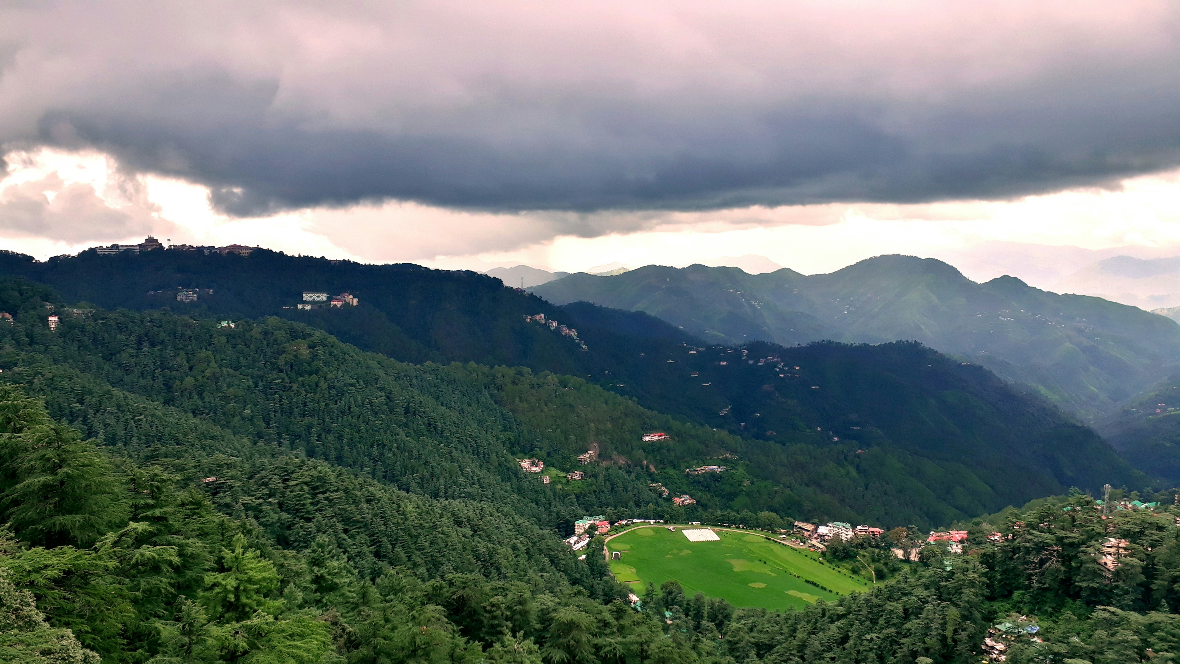 Une vallée verdoyante entourée de montagnes sous un ciel nuageux photo ...