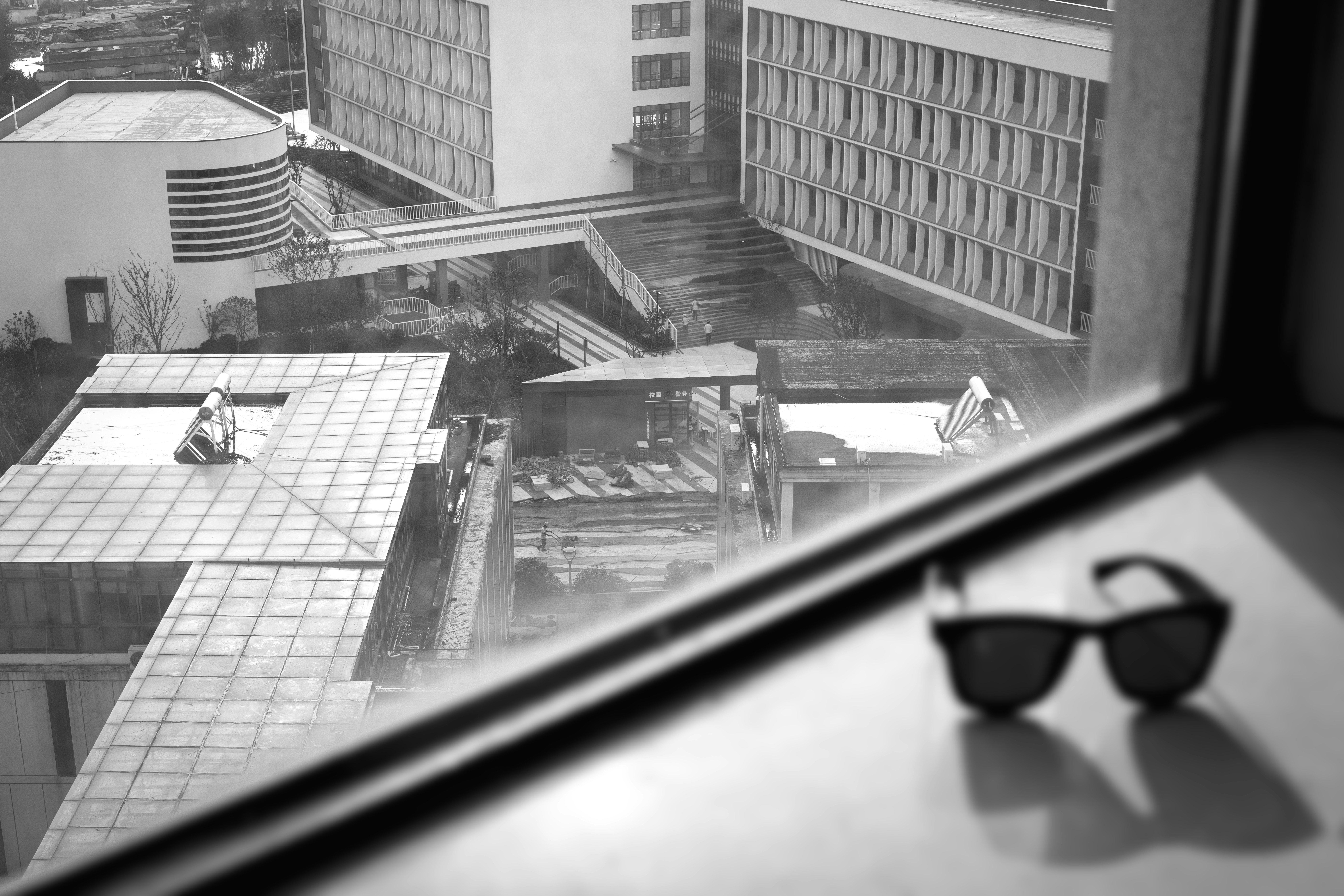 Edge of Light: Sunglasses Keep Watch Over a Monochrome Rooftop