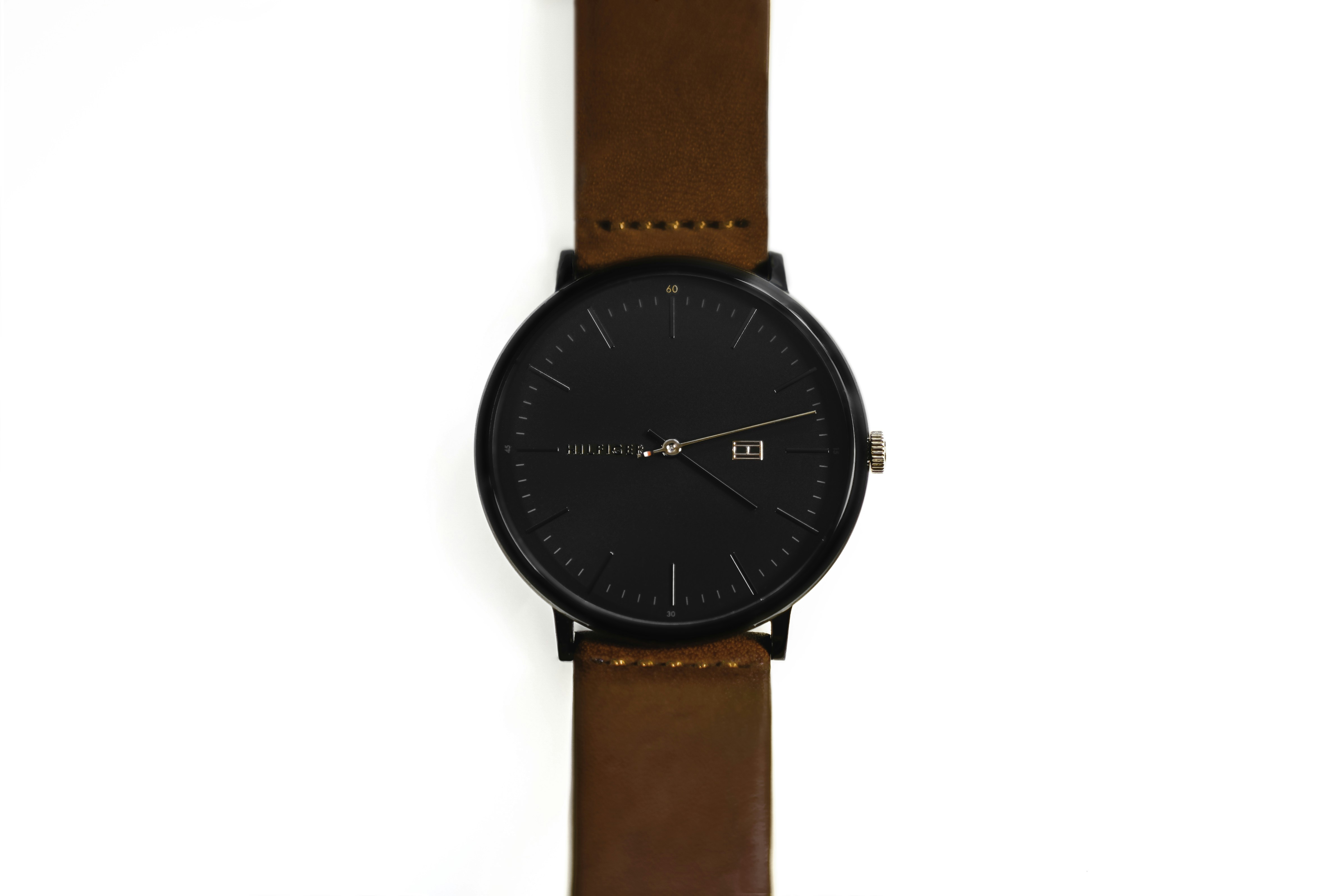 Minimalist black watch with a sleek leather strap, showcasing a clean face and subtle date display.