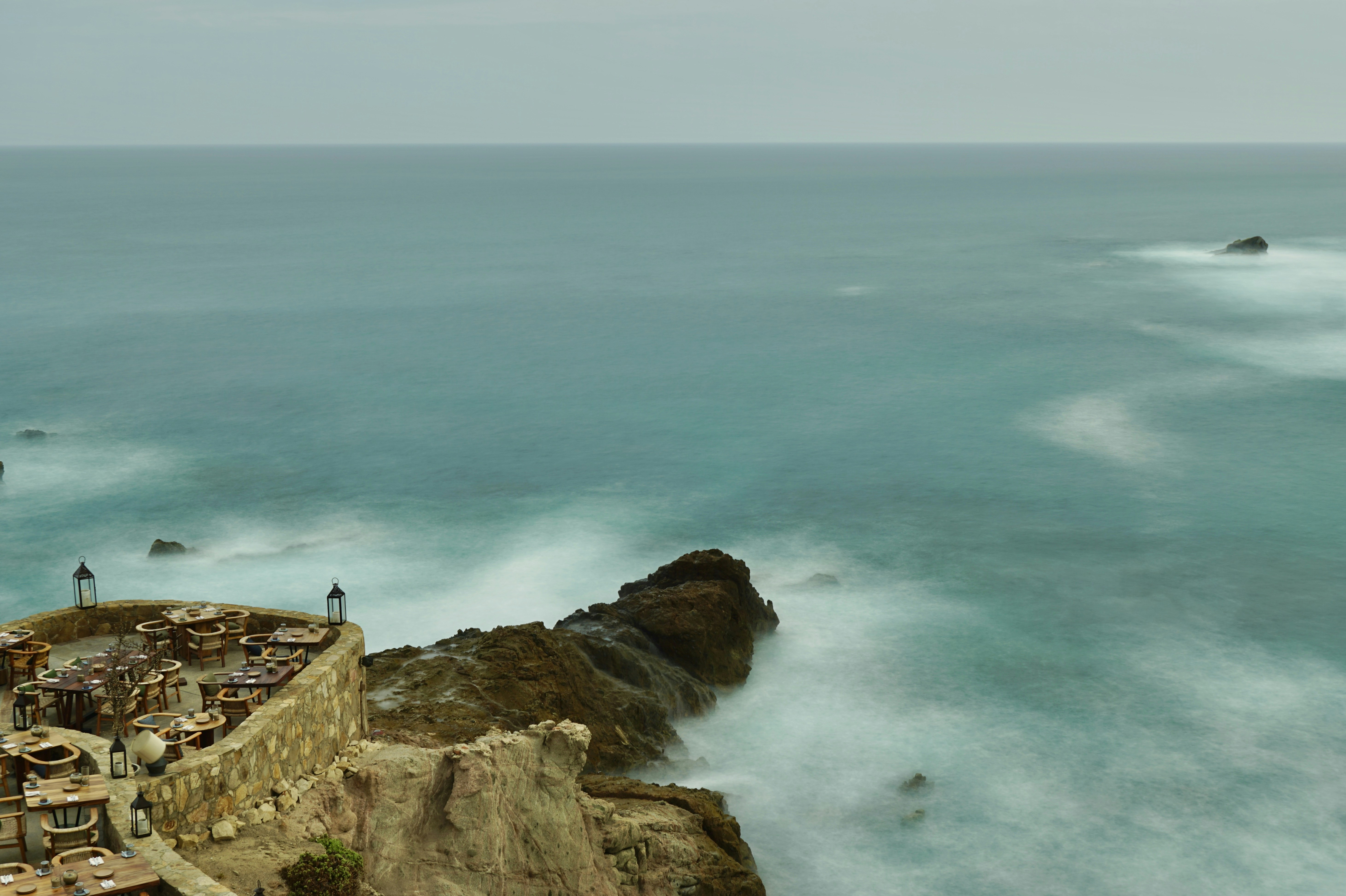 Terraced Cliffside Café Beside a Turquoise, Long-Exposure Sea