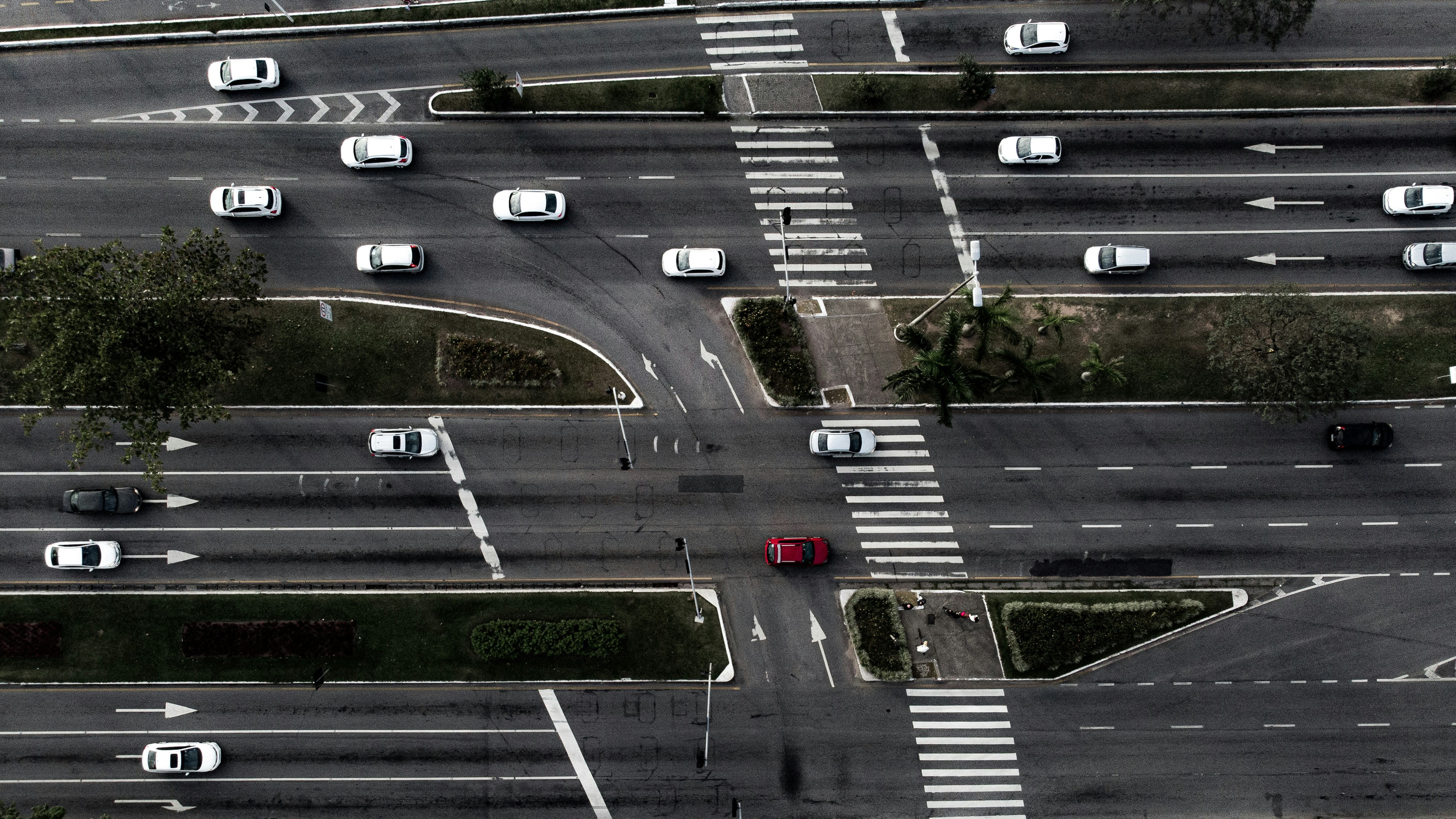 Aerial view of a busy city intersection with numerous vehicles navigating the lanes.