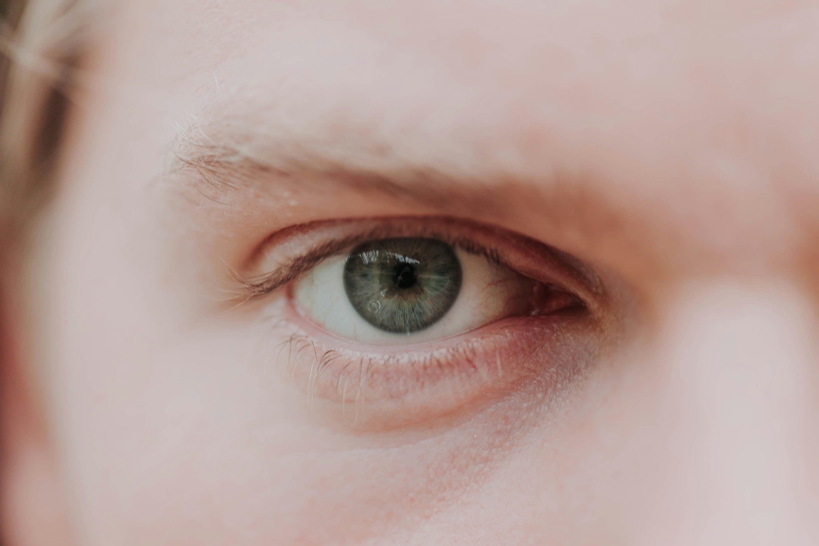 Close-up of a human eye revealing intricate details and reflections within the iris. The focus highlights the unique color and texture of the eye.