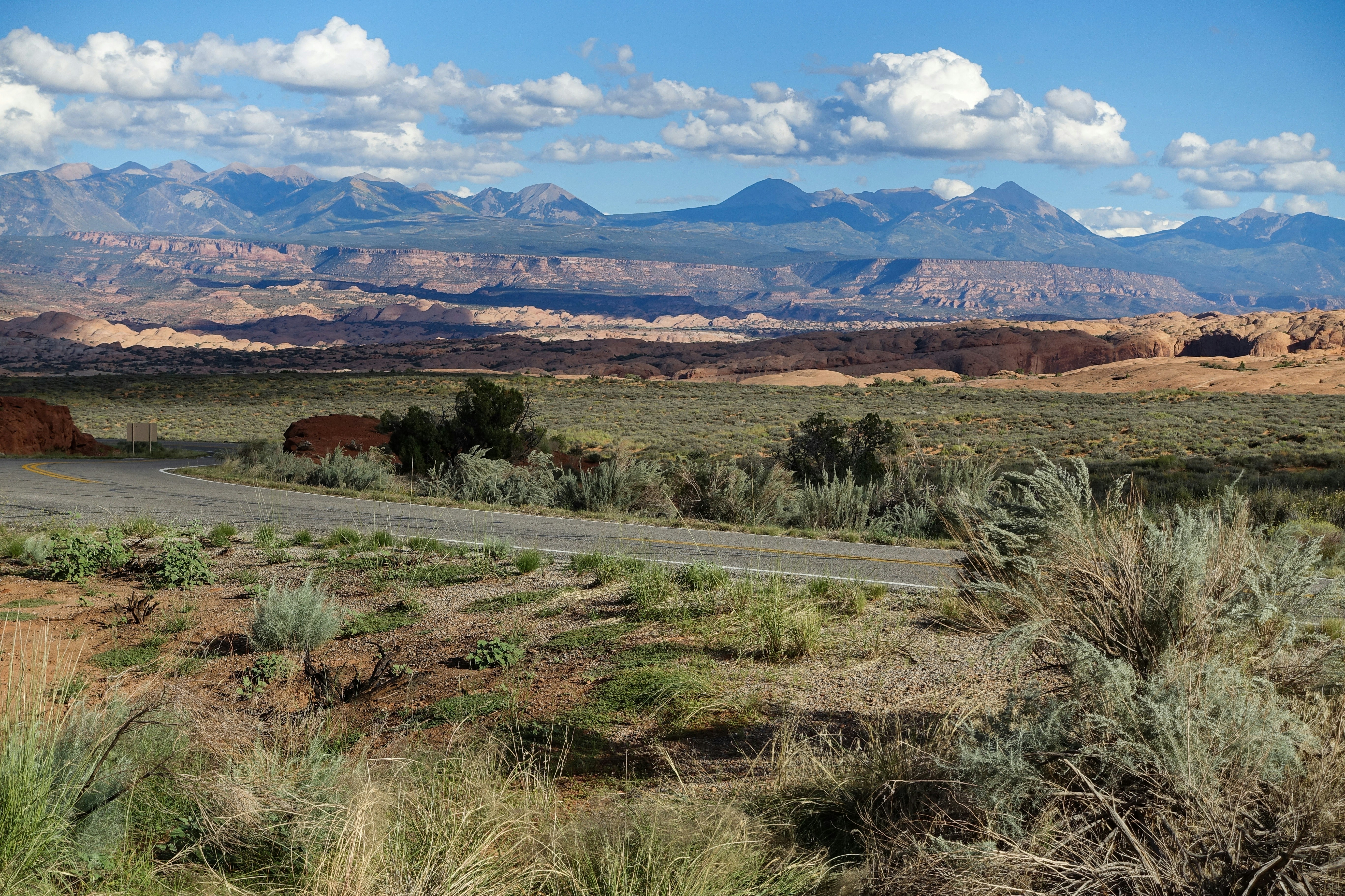 Desert Road to distant mesas under a bright sky