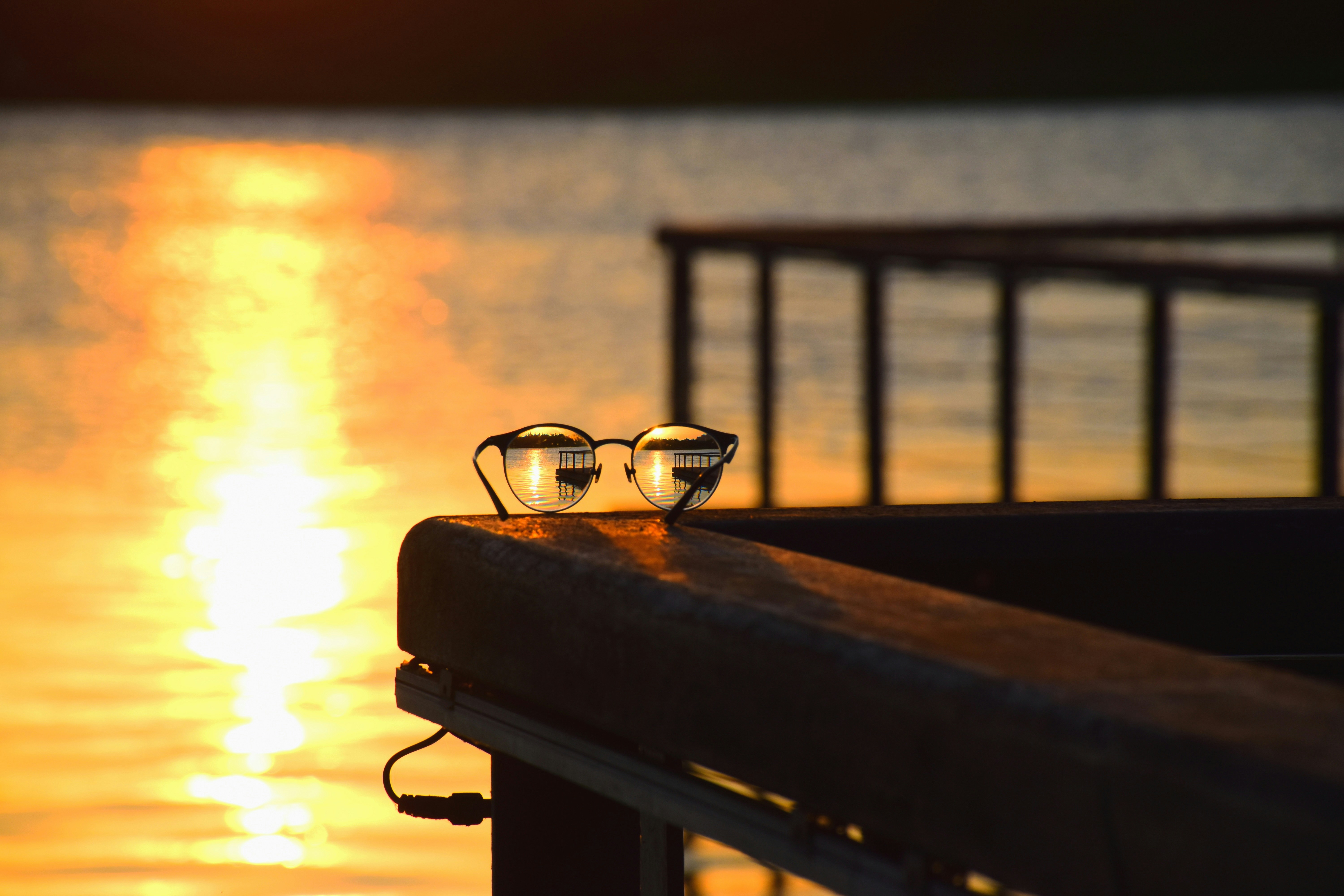 Glasses at Sunset: Quiet Focus by the Railing