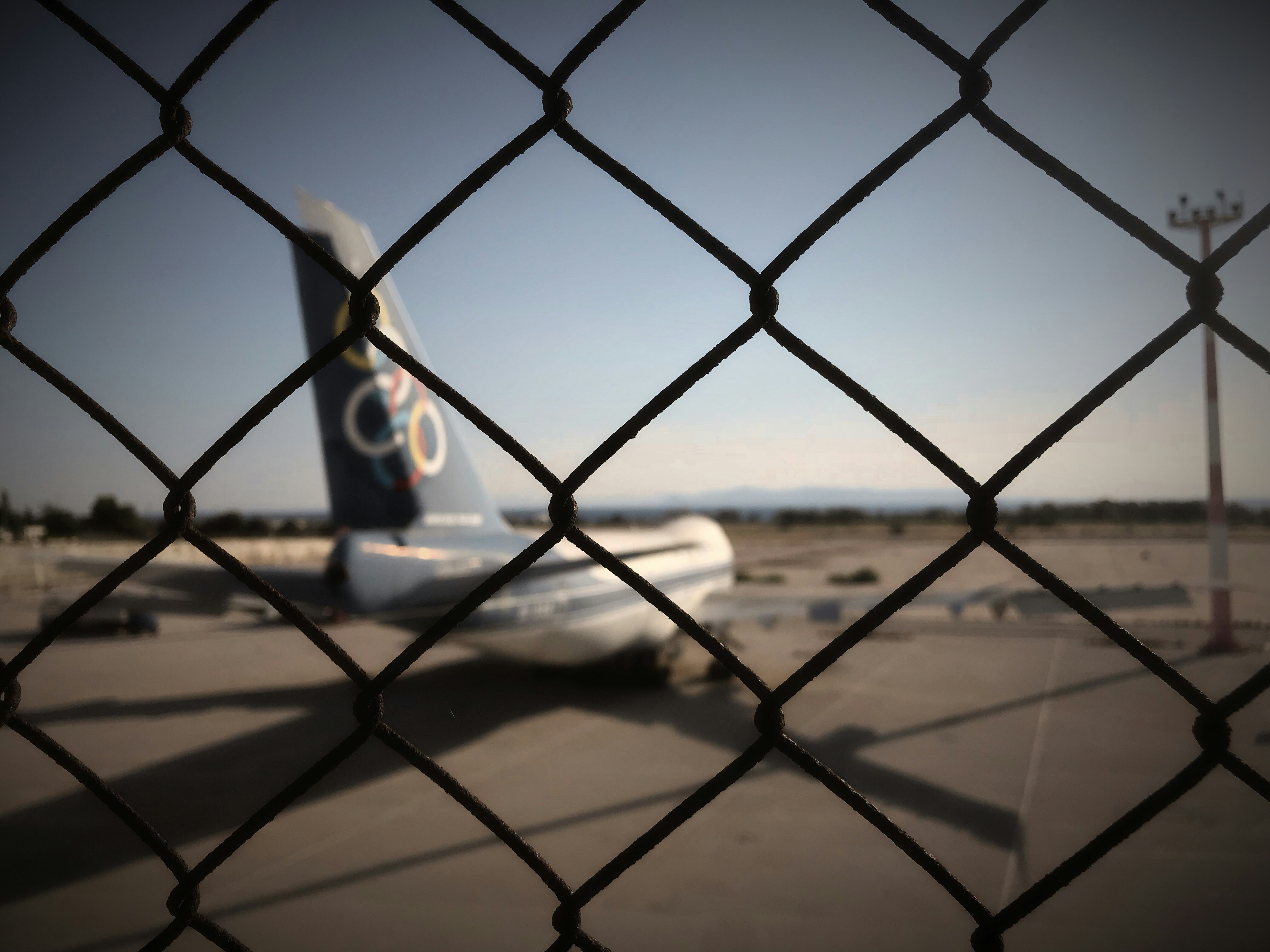 Fence-Framed Quiet: An Airliner Beyond the Mesh
