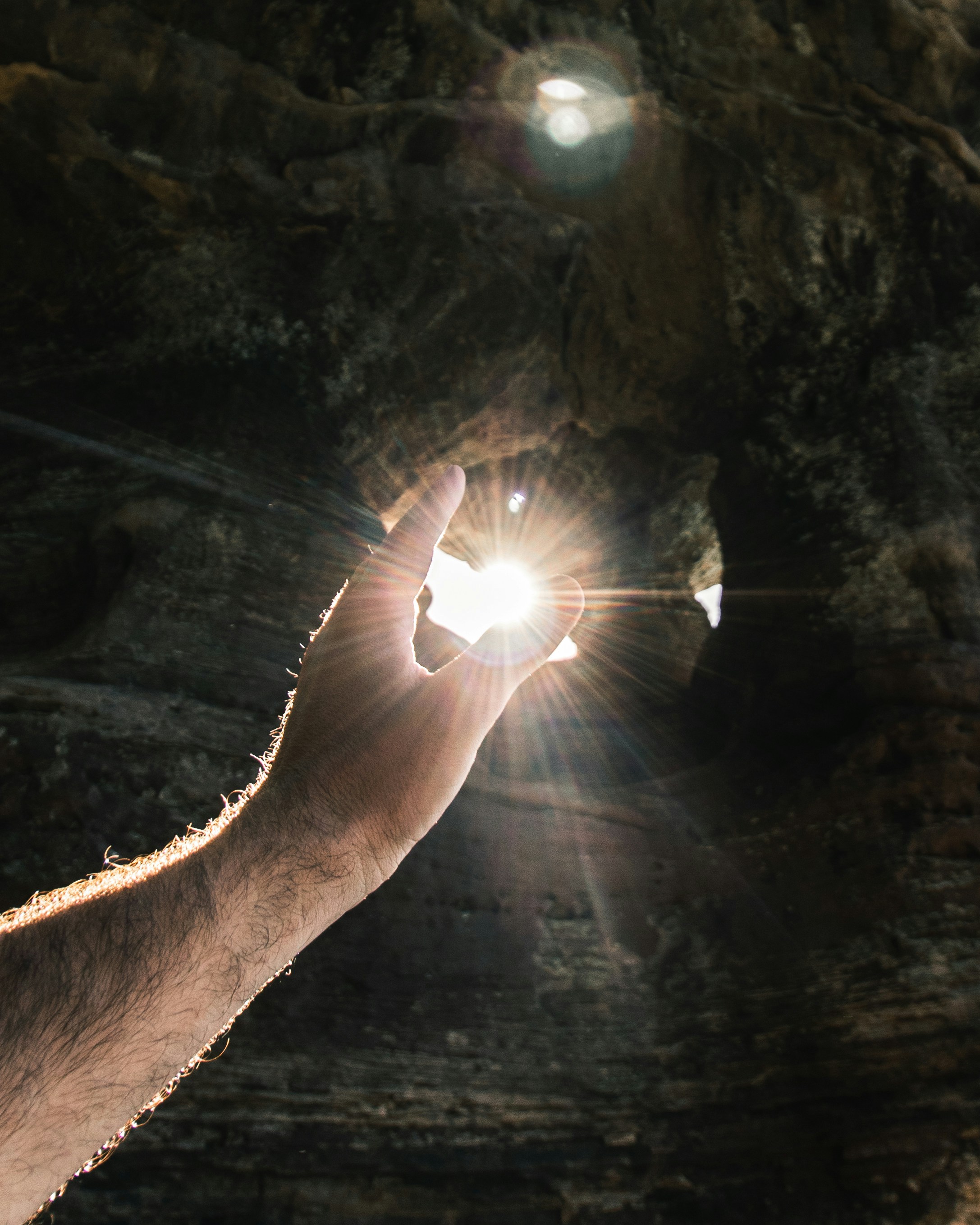 Hand Reaches for the Sun Through a Narrow Canyon