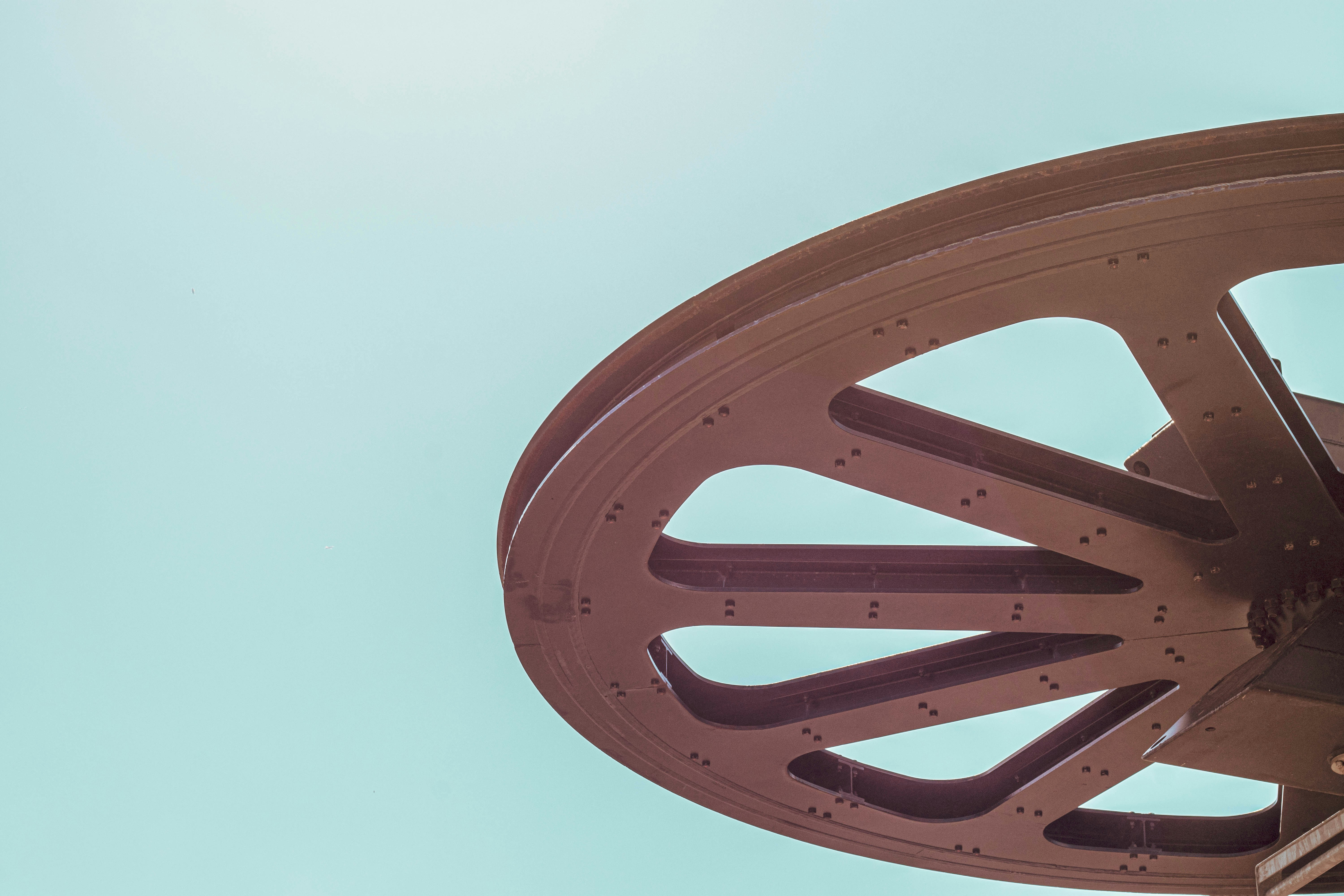 Rusted Spoked Rim Against a Calm Blue Sky
