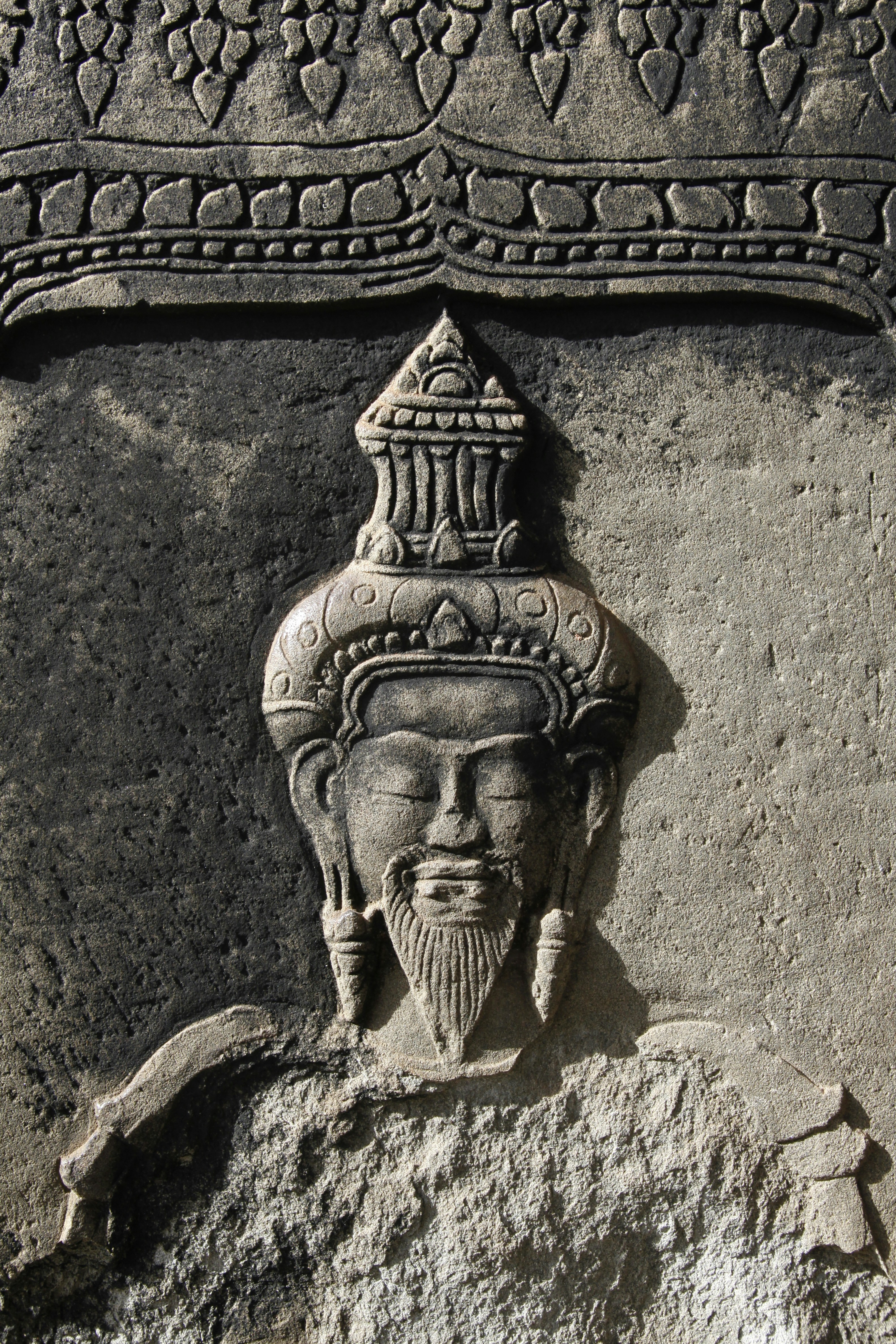 Crowned Sage in Stone: A weather-worn guardian carved in sandstone