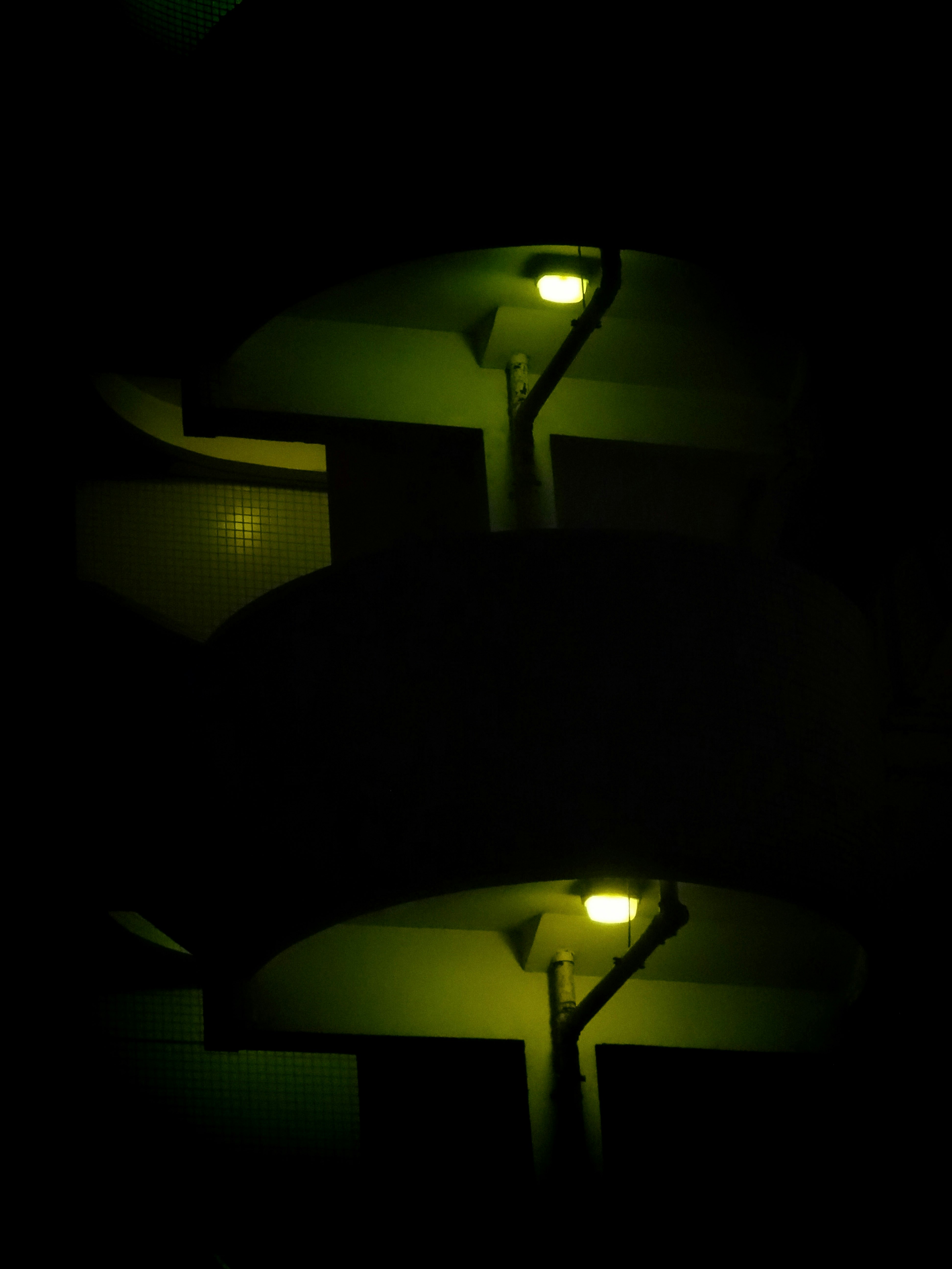 Green-lit architectural elements create a striking contrast against the dark background, emphasizing the interplay of light and shadow.