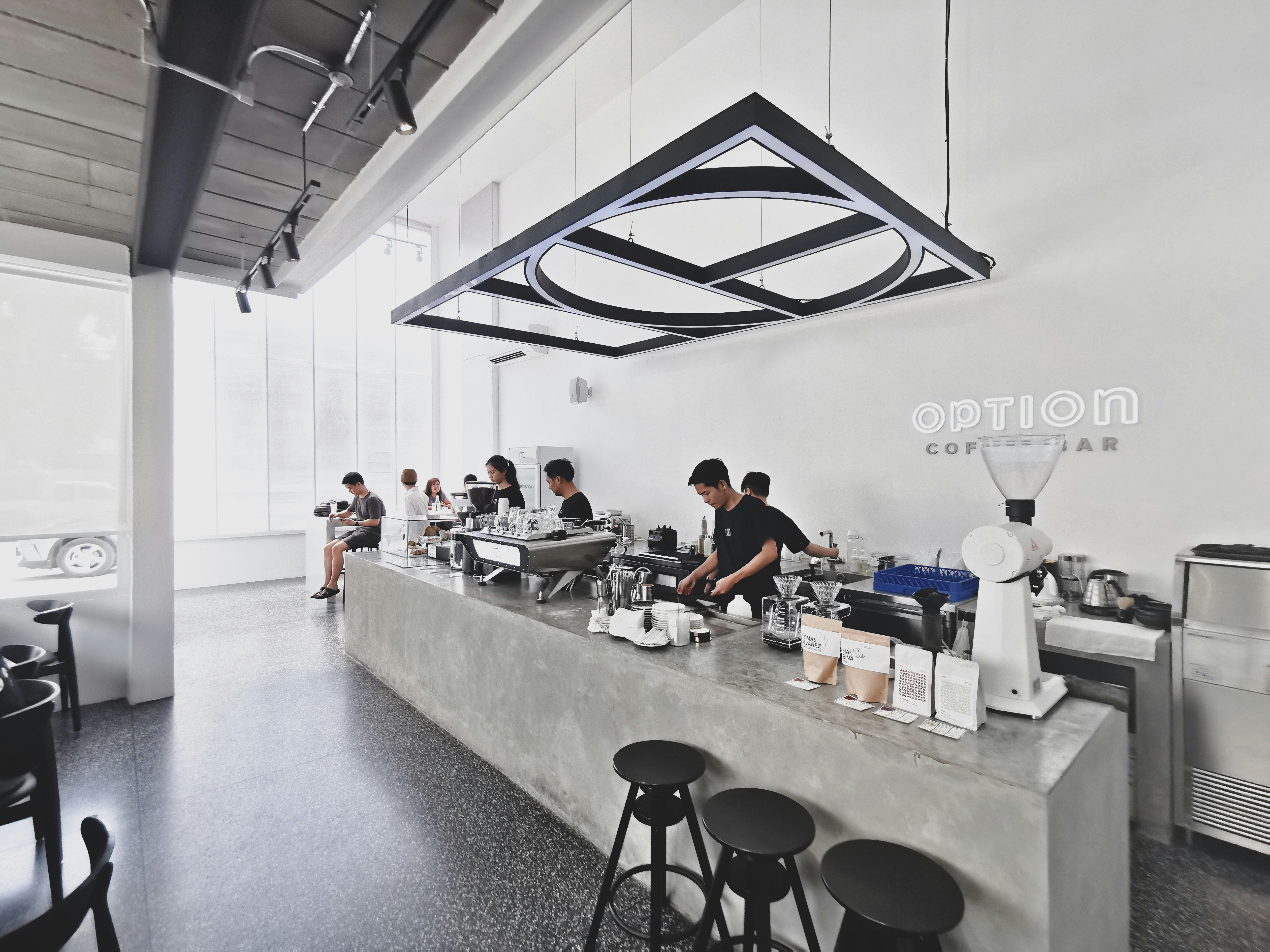 Sleek coffee bar featuring a contemporary design with baristas preparing drinks and patrons enjoying the ambiance.