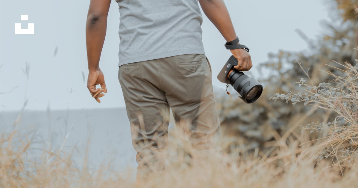 Hombre Sosteniendo Una Cámara Dslr Mientras Camina Foto Imagen De