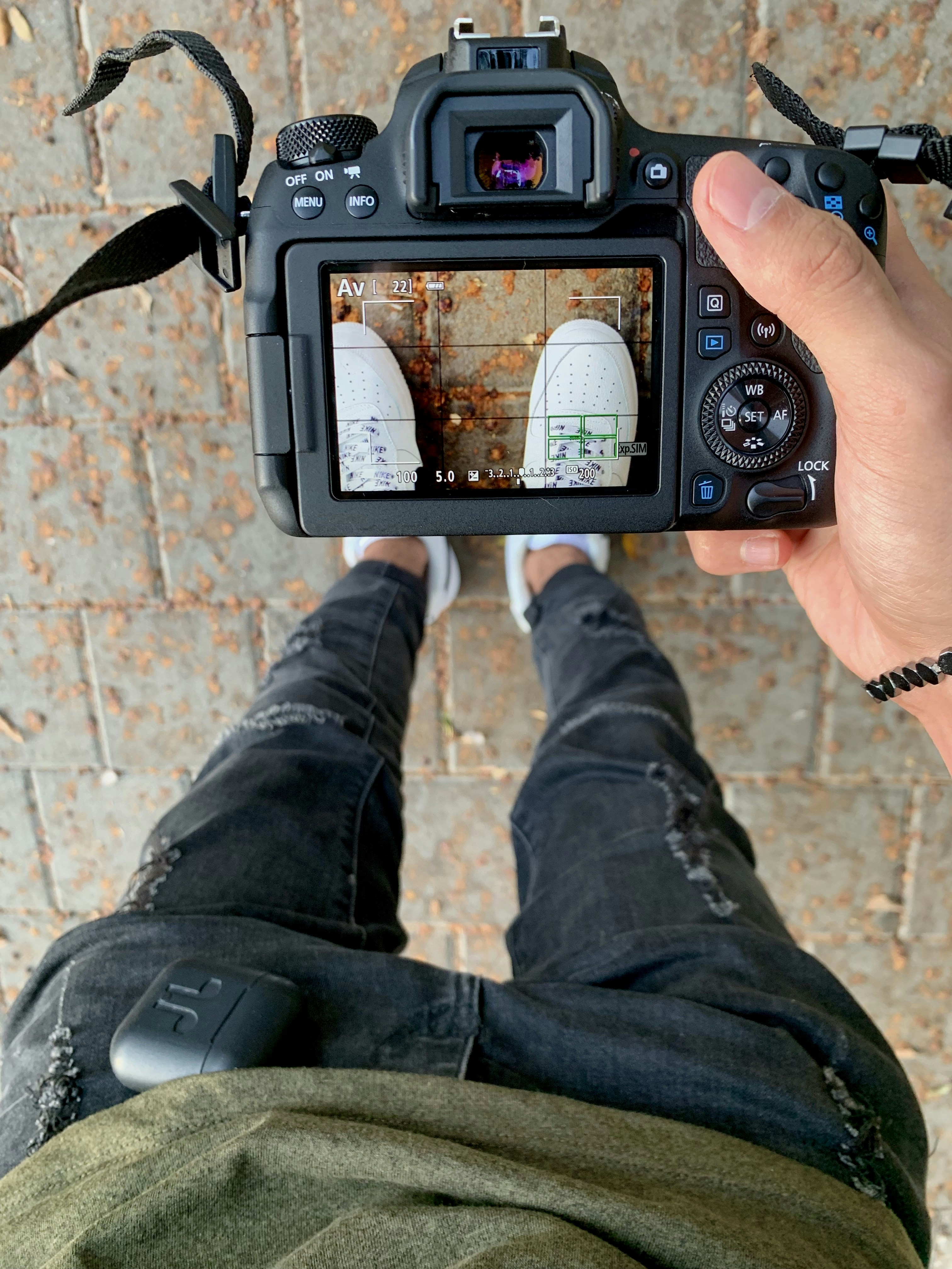 Person using DSLR camera and taking photo of white sneakers photo ...