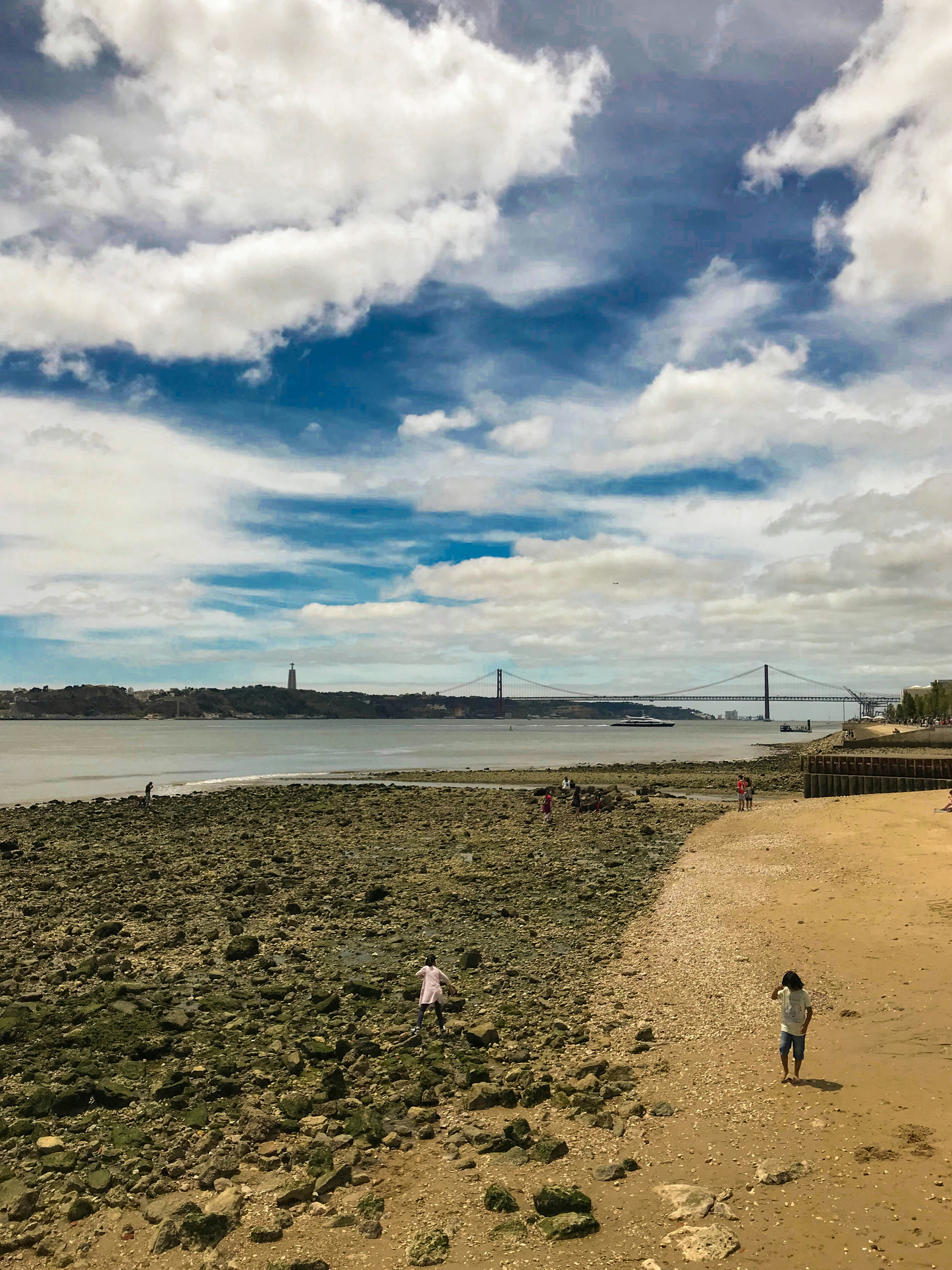 Toward the Distant Bridge: A Quiet Coastal Walk Along Rocky Shoreline