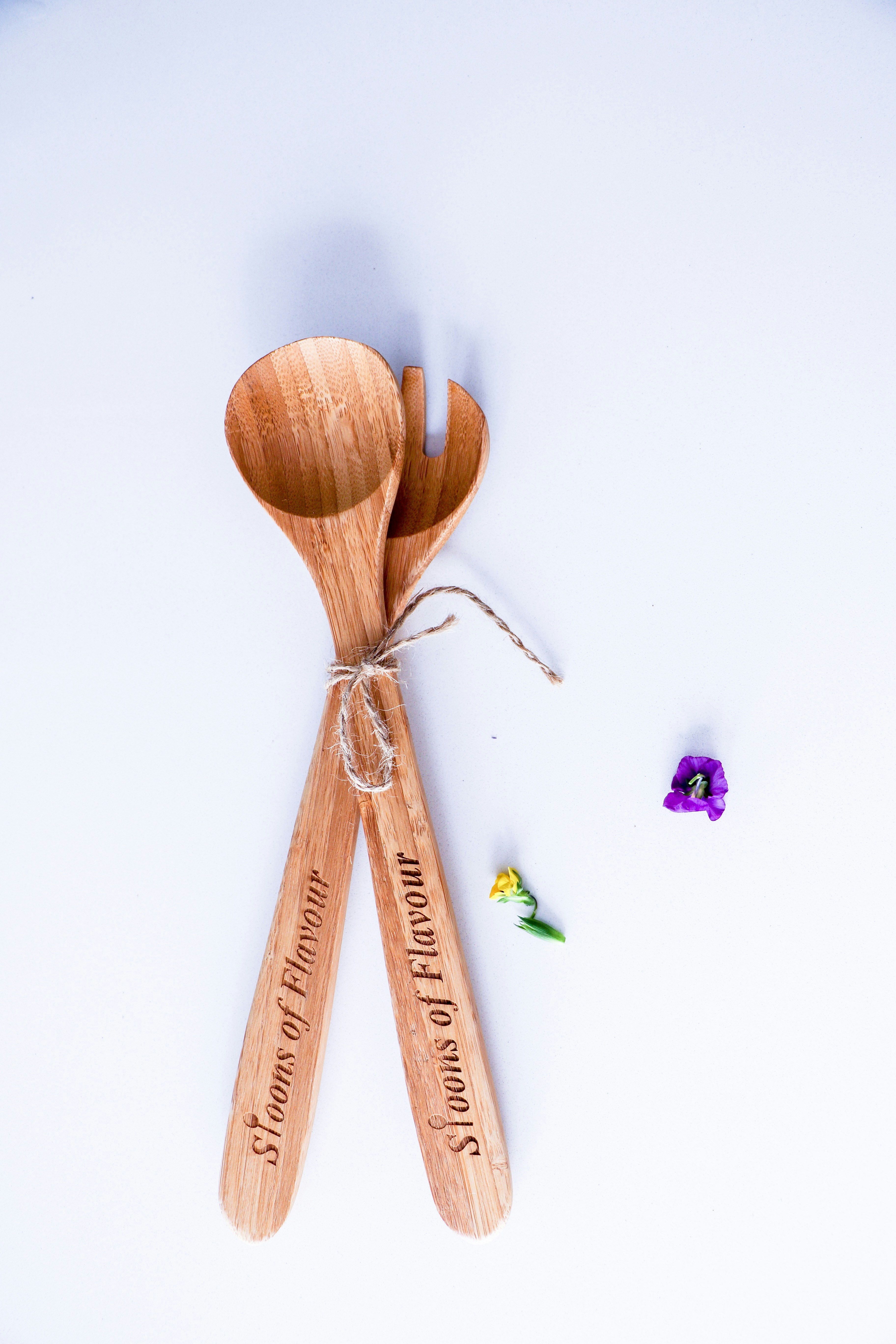 Twin Wooden Spoons Bound by Twine on a White Canvas