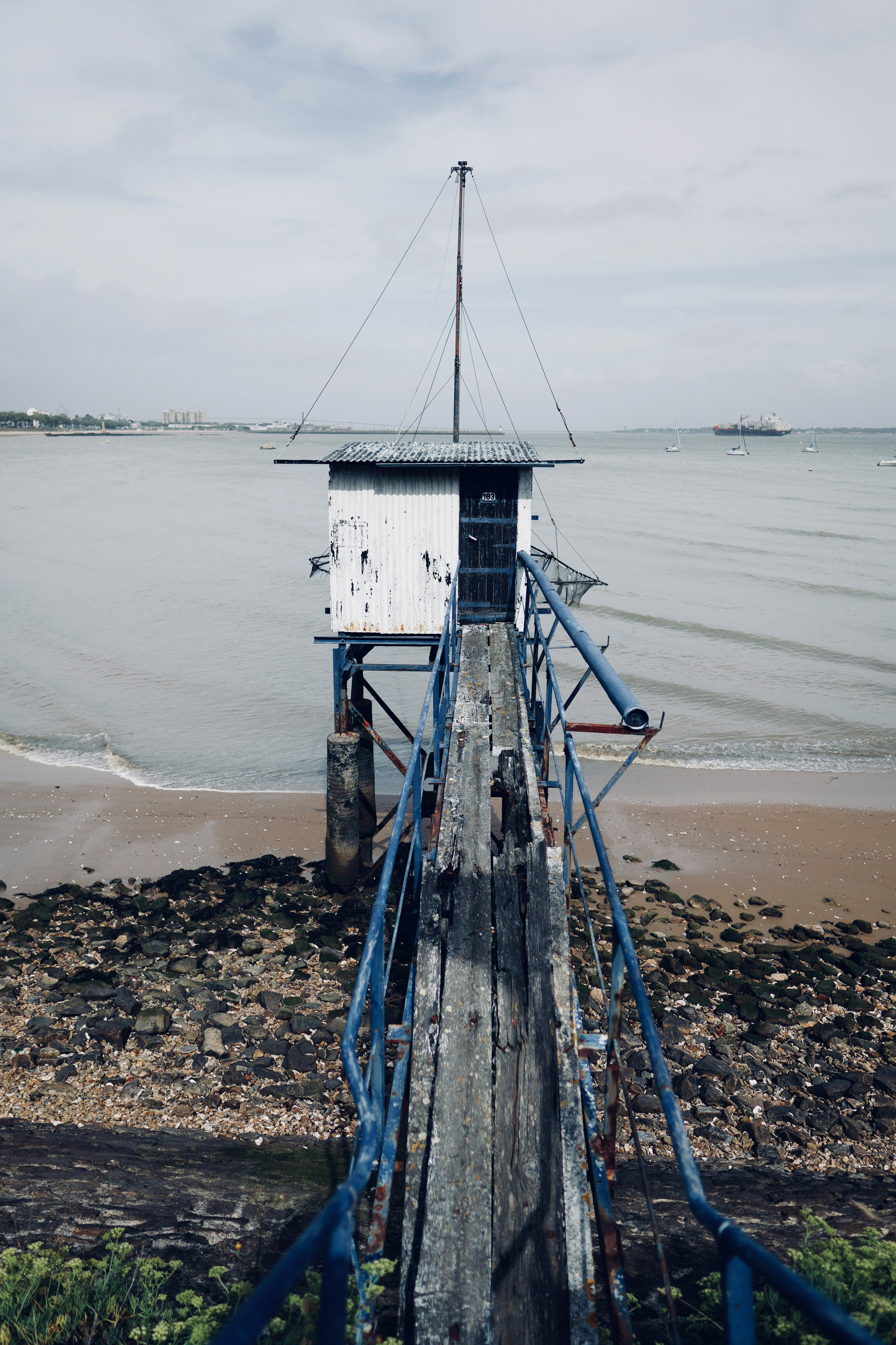 Balustraded Pier to the Sea: A Weathered Lifeboat Hut Looms Over the Tides