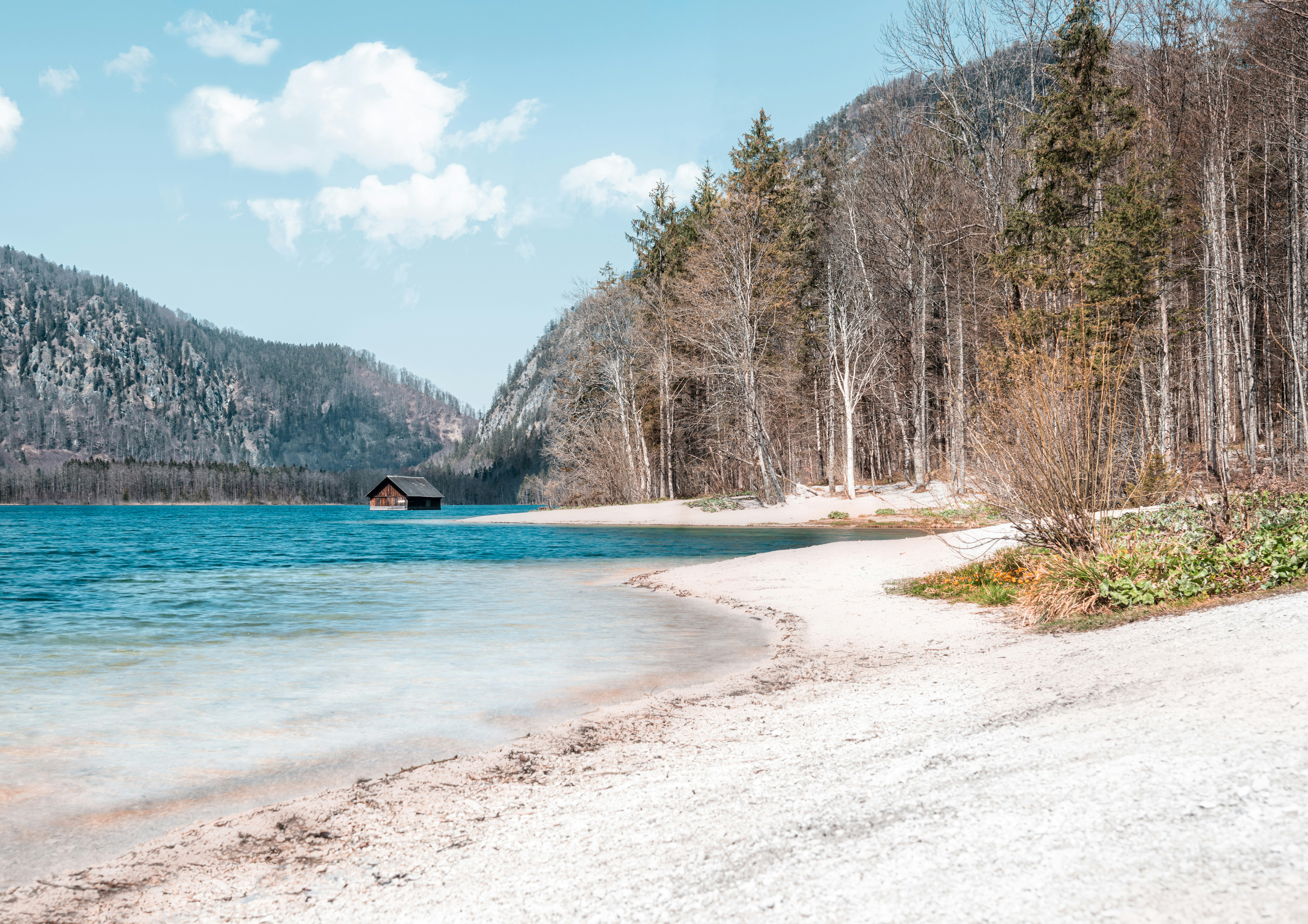 Lone Hut at the Edge of a Snow-Washed Alpine Lake