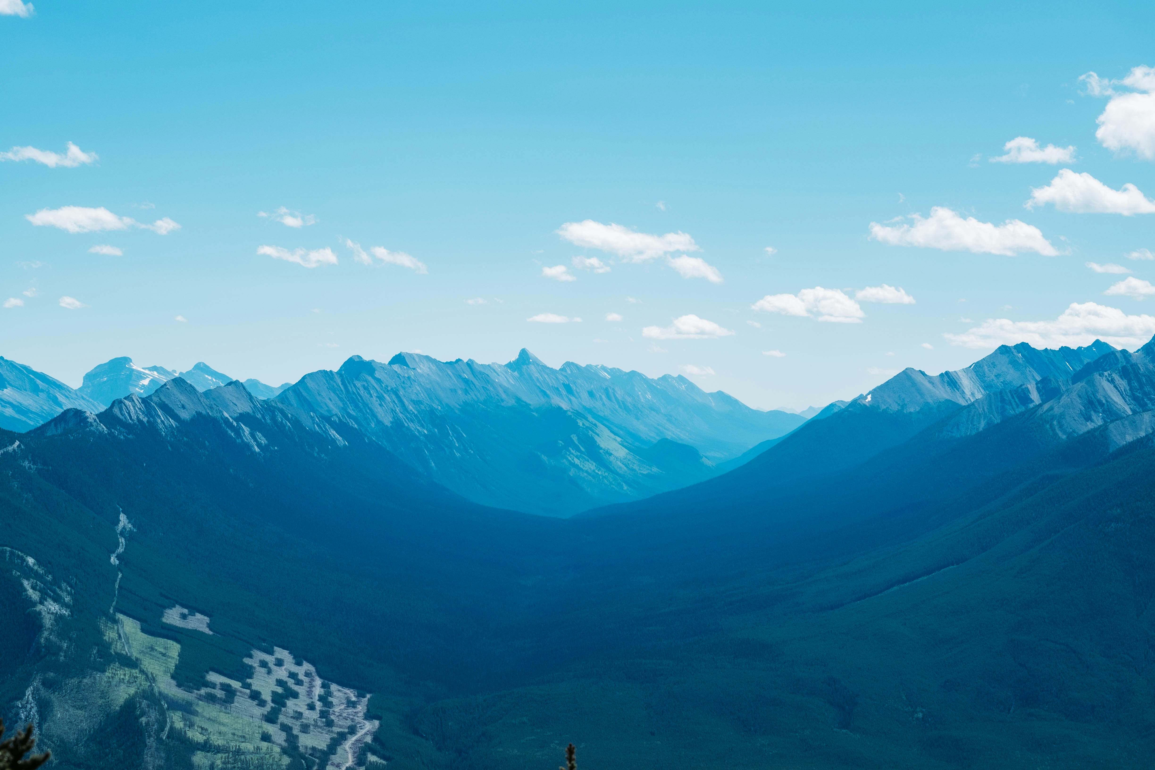 A view of a mountain range from a high point of view photo – Free Blue ...