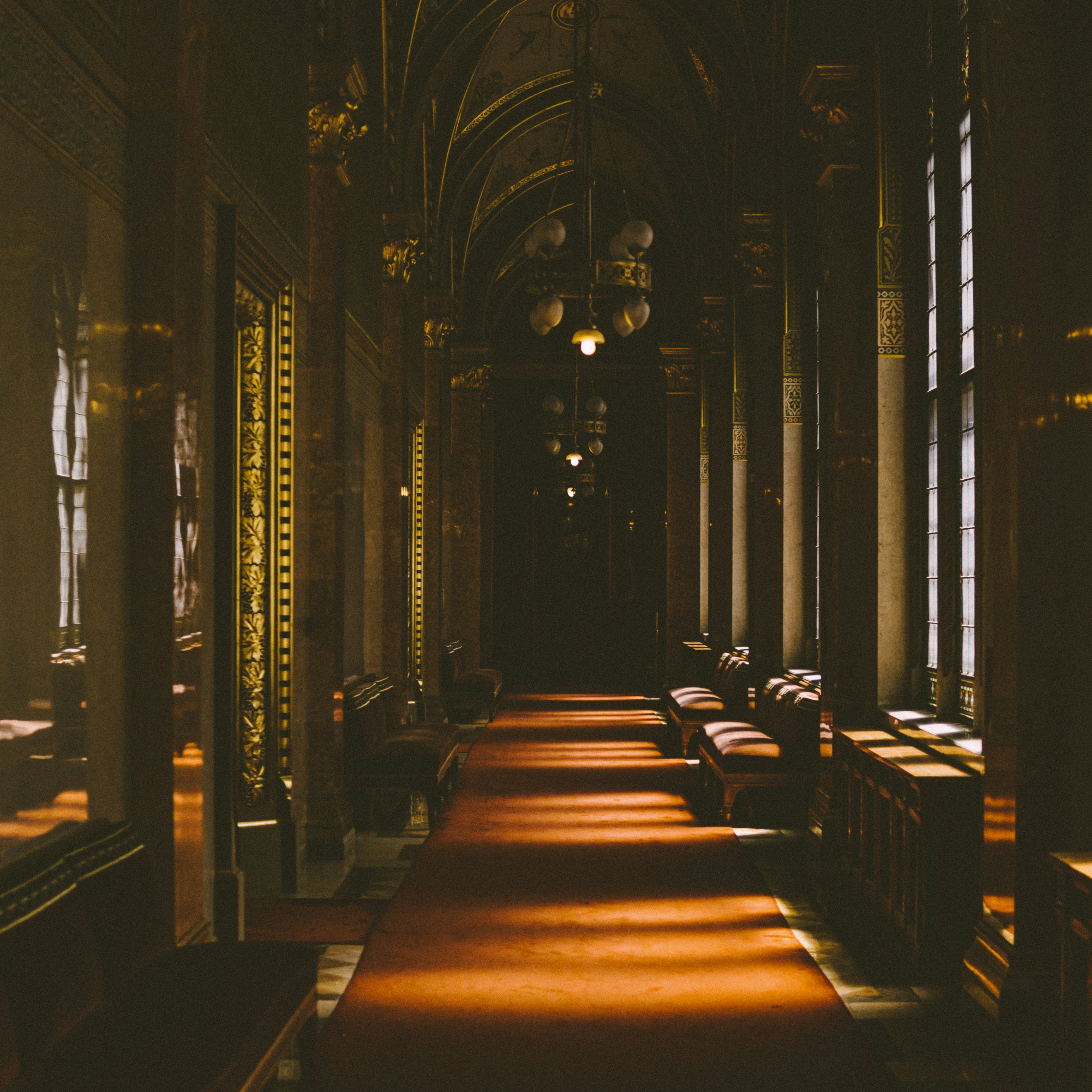 Golden Corridor: Sunlit Columns and Velvet Carpet Vanishing into Dusk