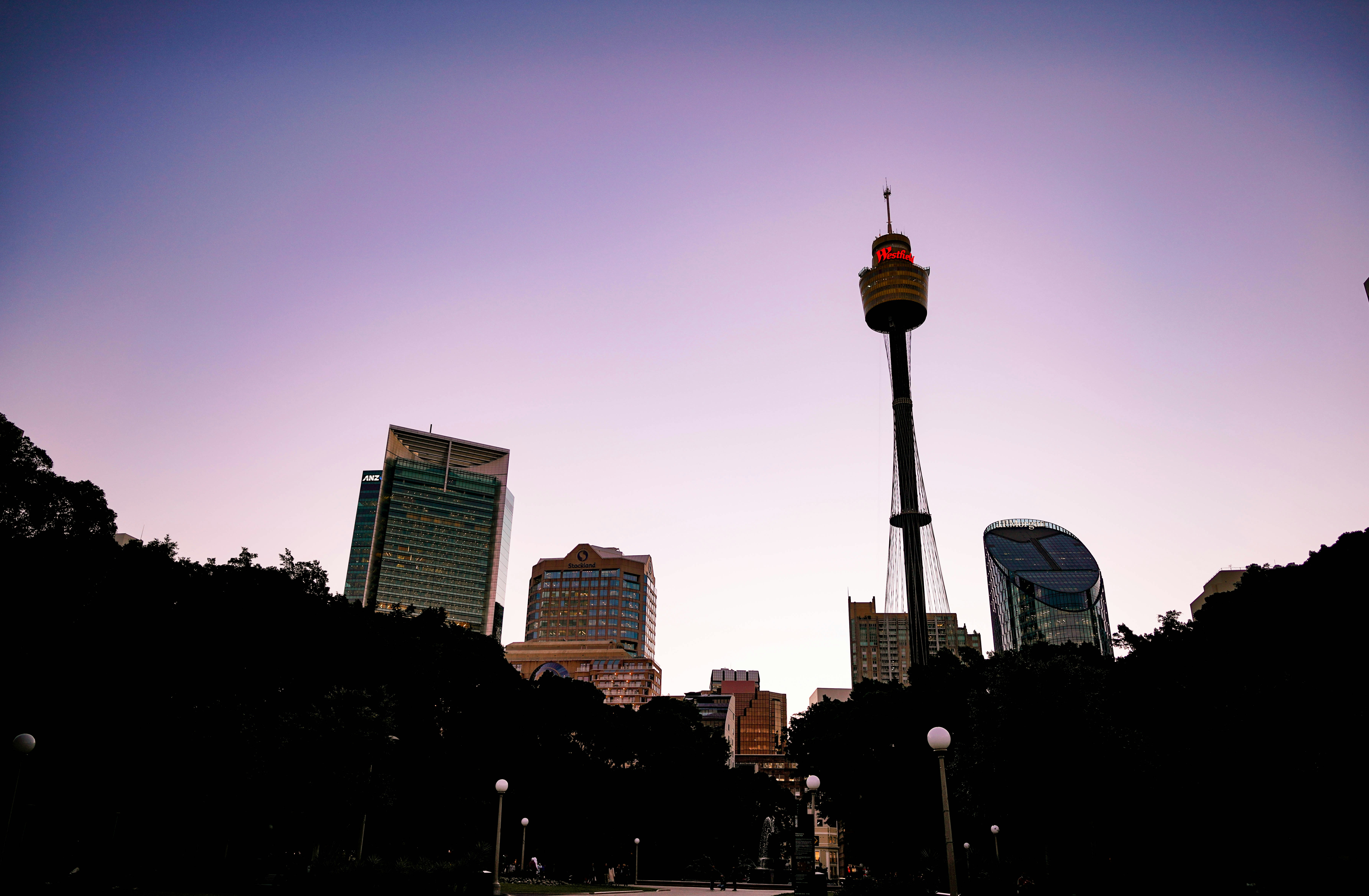 Silhouetted skyline featuring a prominent observation tower against a gradient twilight sky, framed by urban architecture.