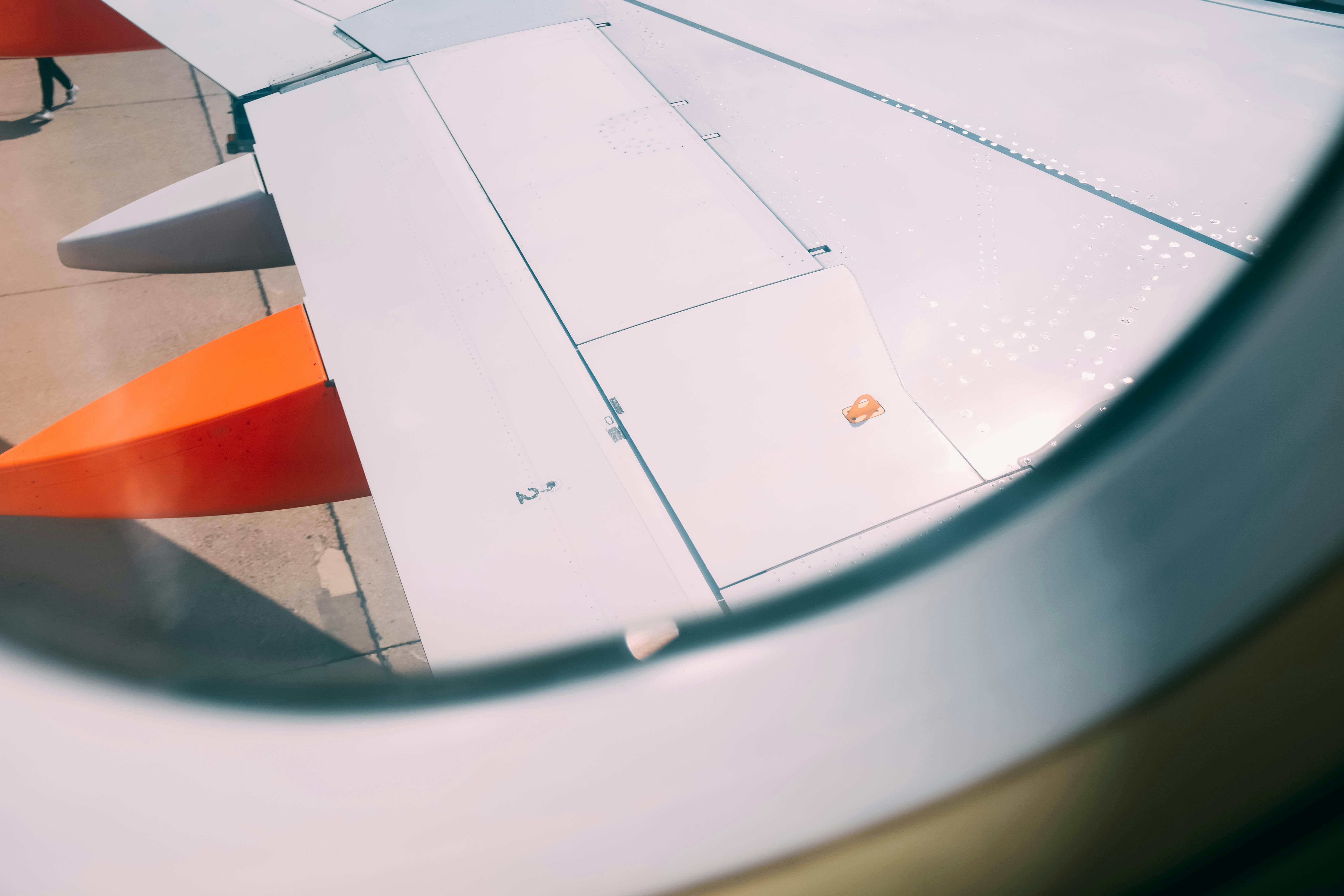 Orange Winglet Through a Circular Window: Quiet Geometry of Flight