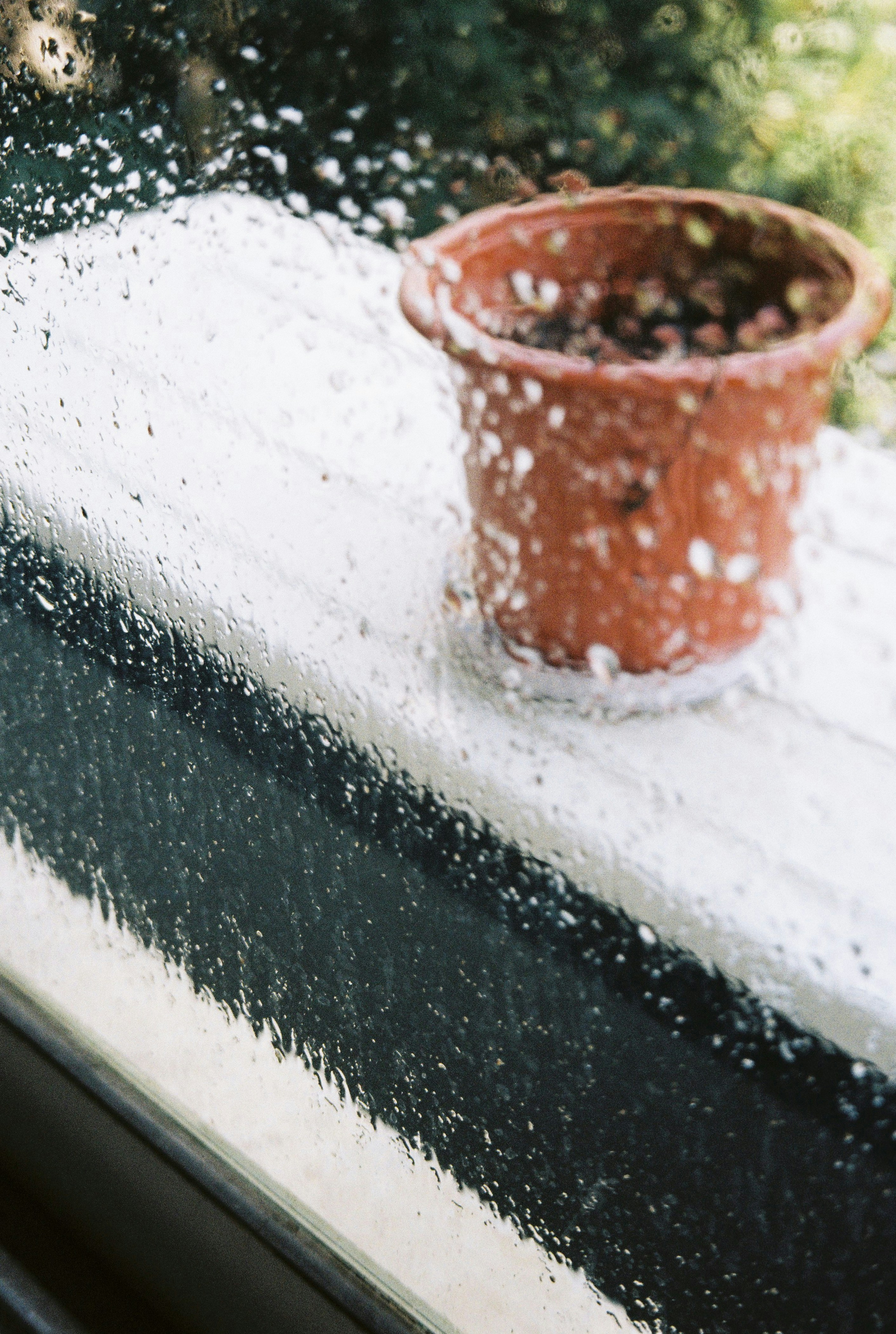 Water-splashed terracotta pot on a snowy windowsill