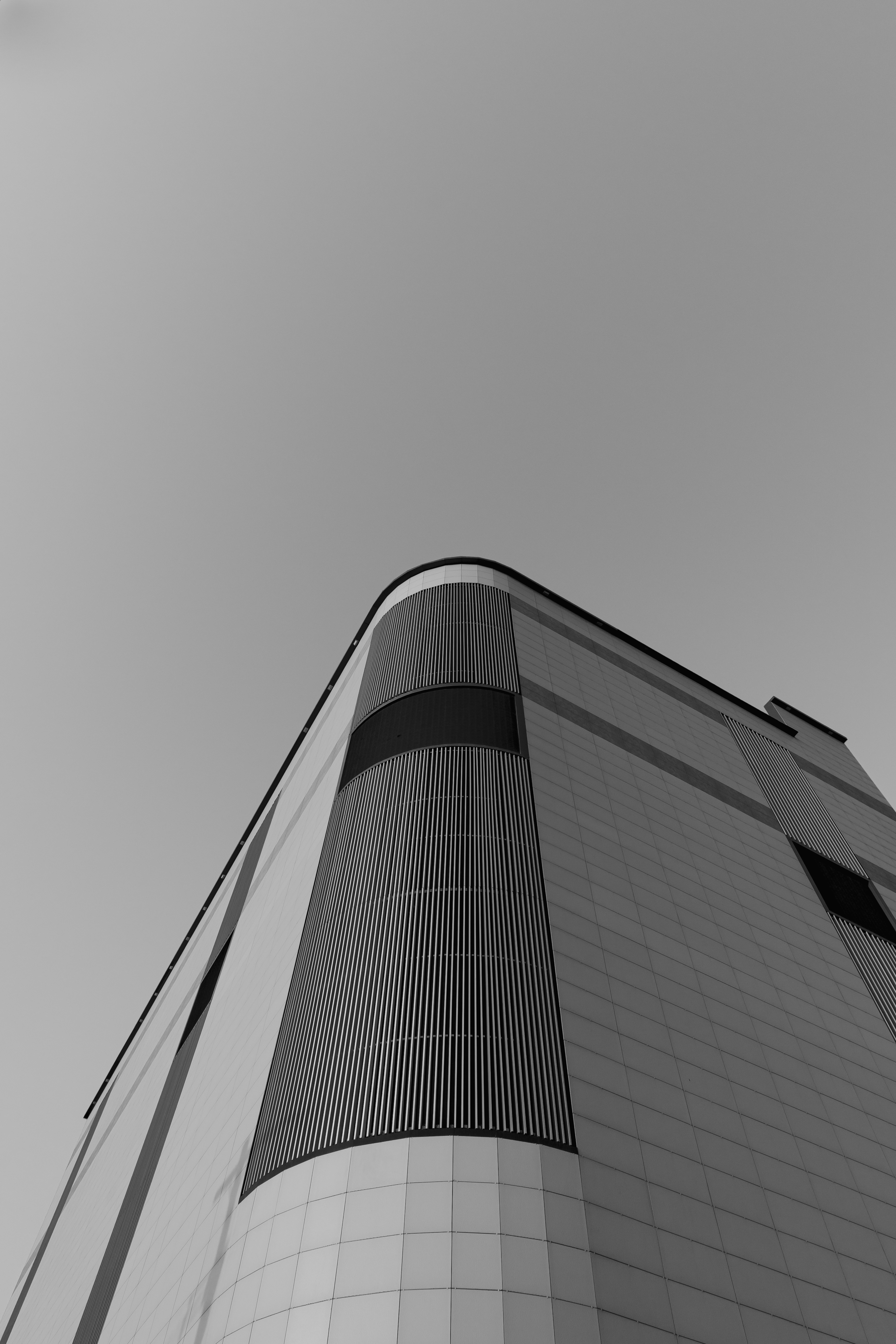 Modern building facade showcasing sleek lines and textures against a clear sky.