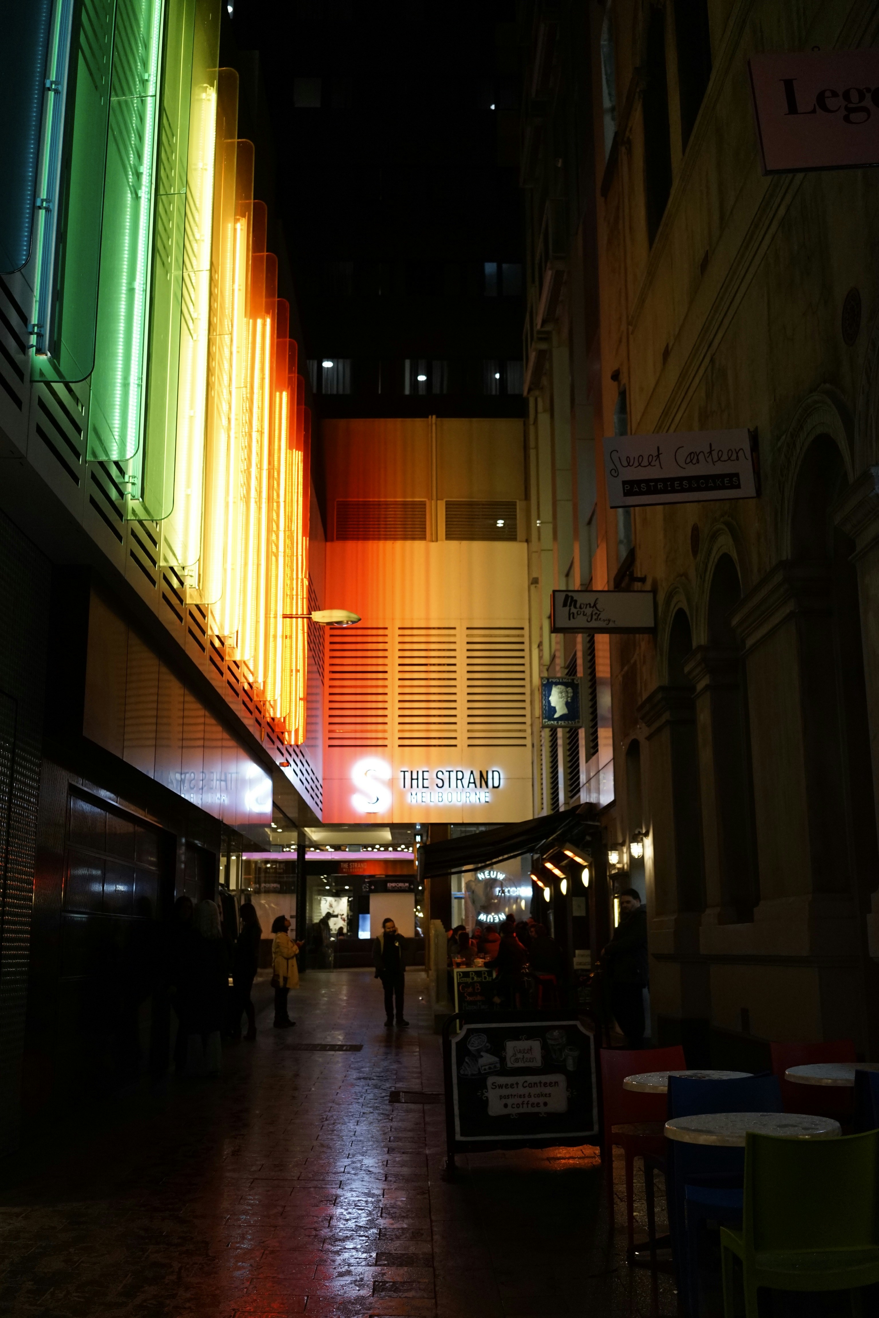 Neon Arches Over The Strand: A Night Walk Beneath Rainbow-Lit Facades
