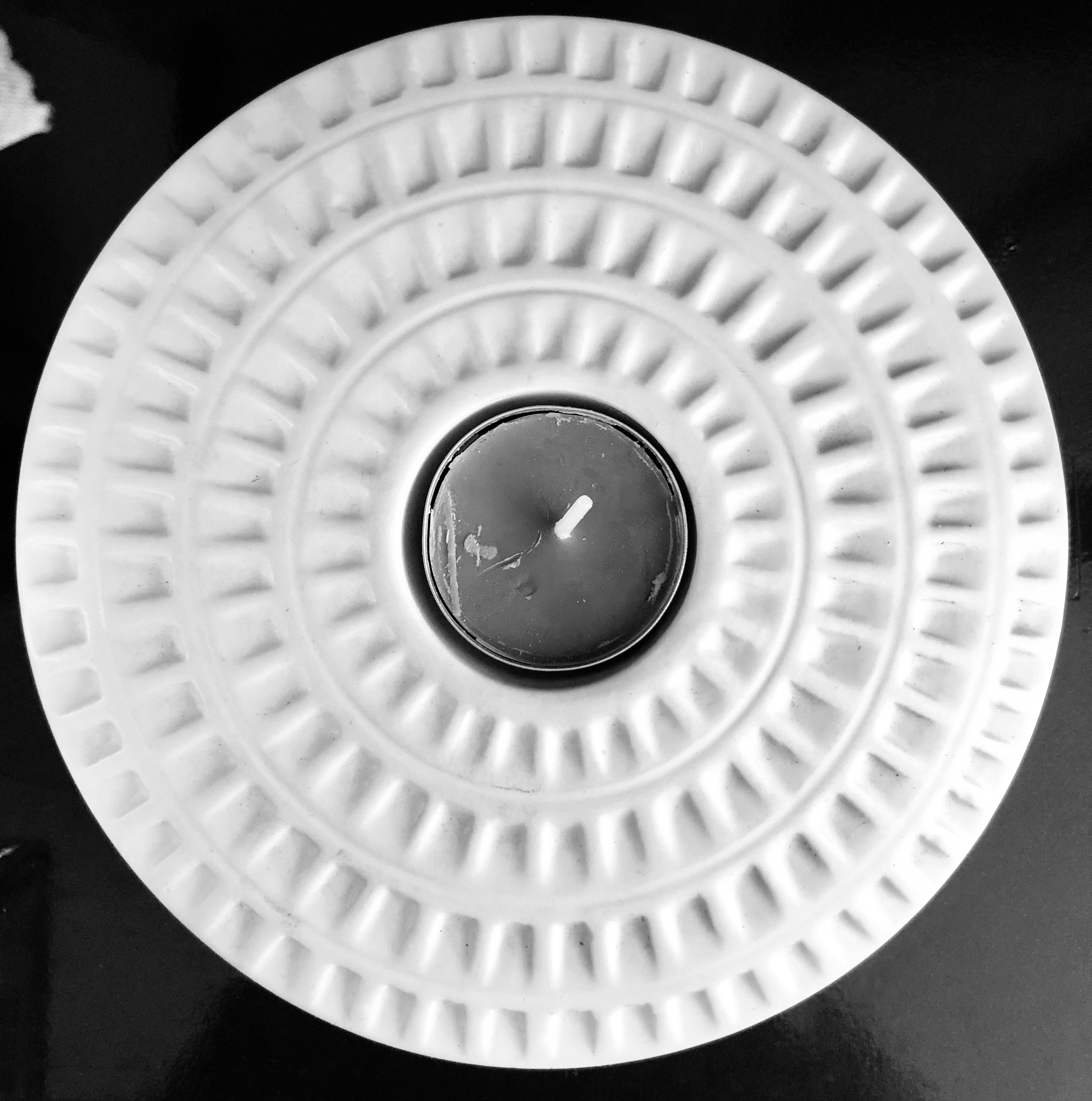 Candle centered in a textured circular pattern, creating a mesmerizing spiral effect.