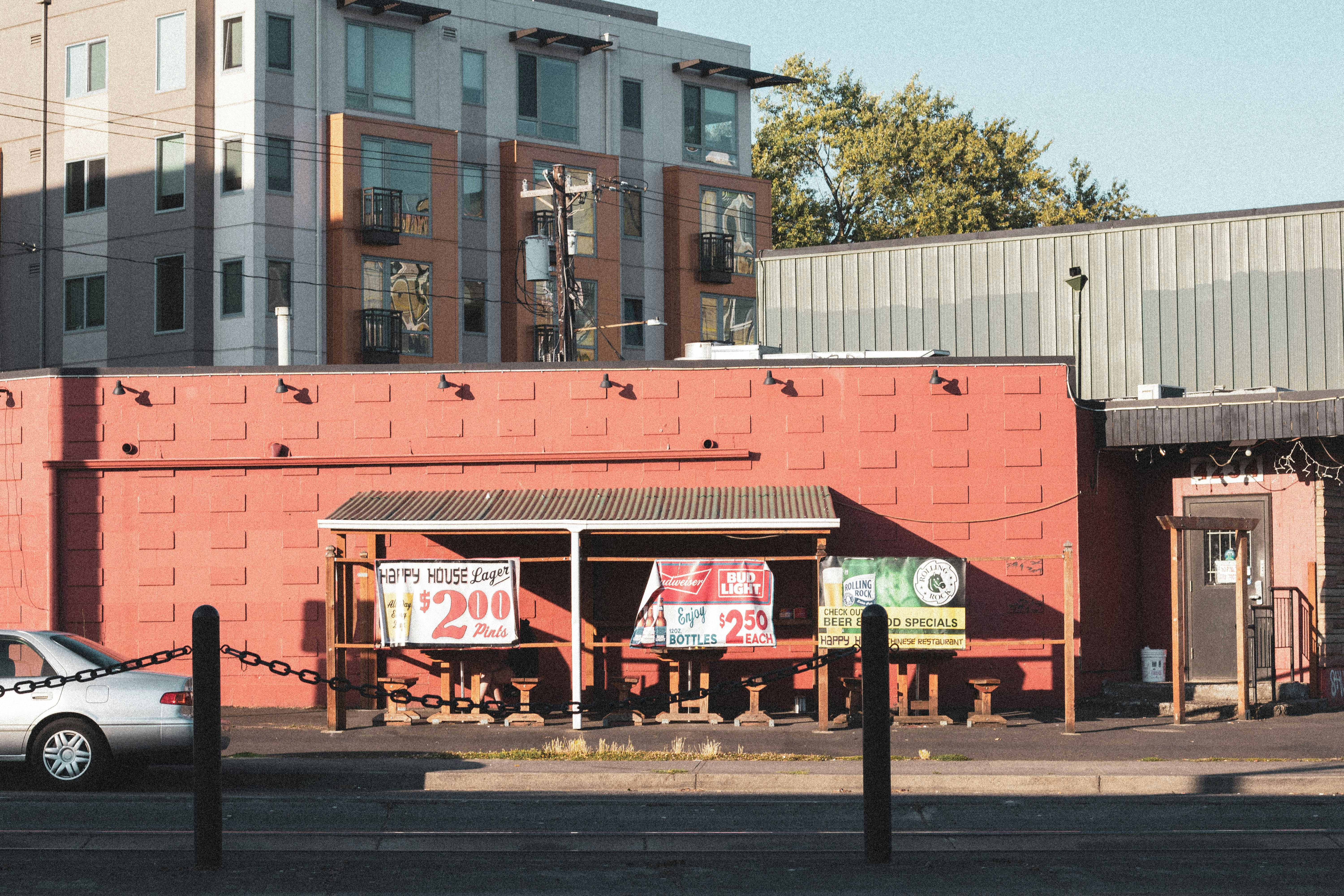 Promotional Banners on a Red Brick Corner Beneath a Modern Apartment Backdrop
