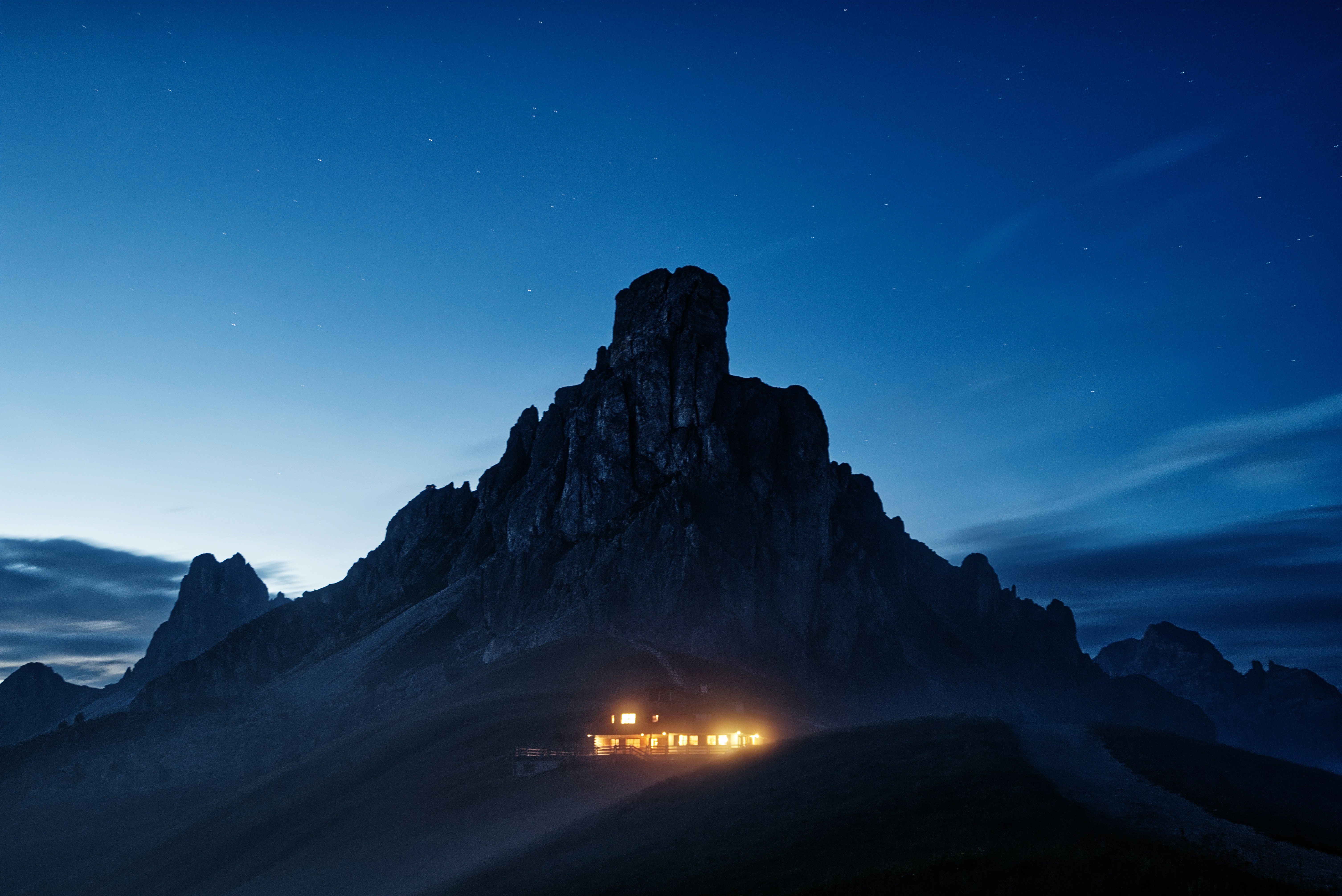 Luminous Cabin Beneath a Jagged Peak