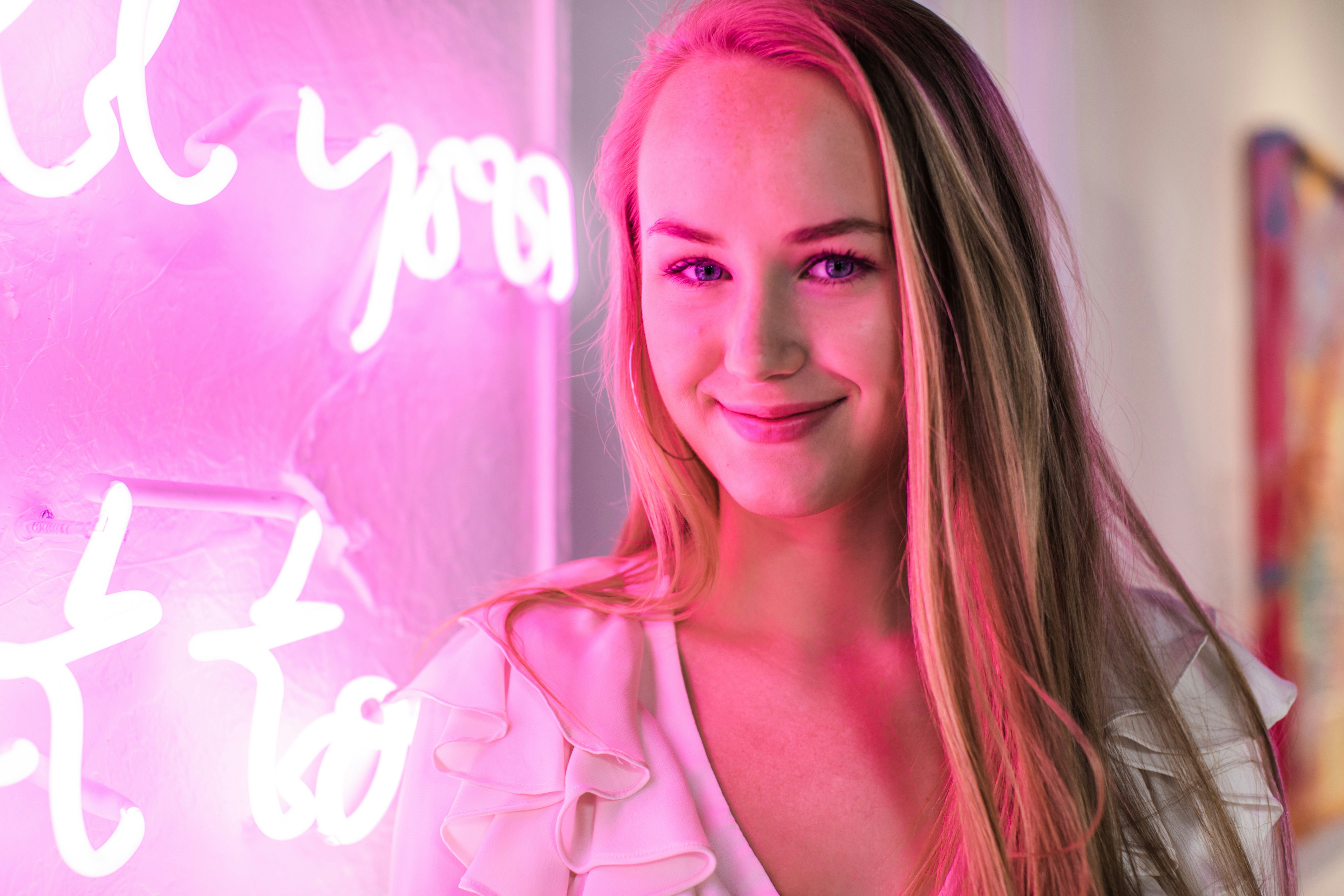 Neon Portrait: A Soft Smile Beneath Pink Neon Glow