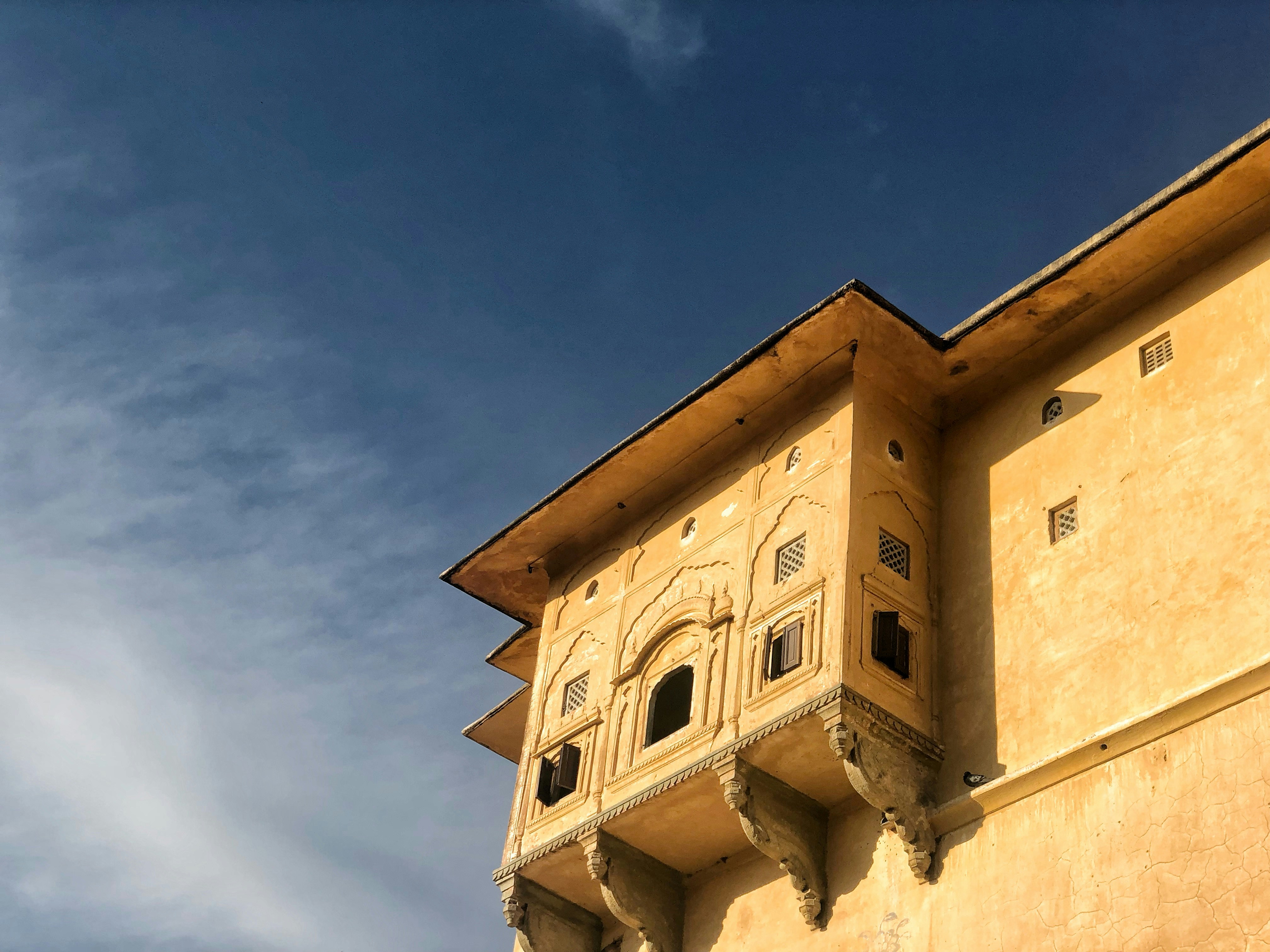 Honeyed Facade Arch: Sunlit Corner Balcony