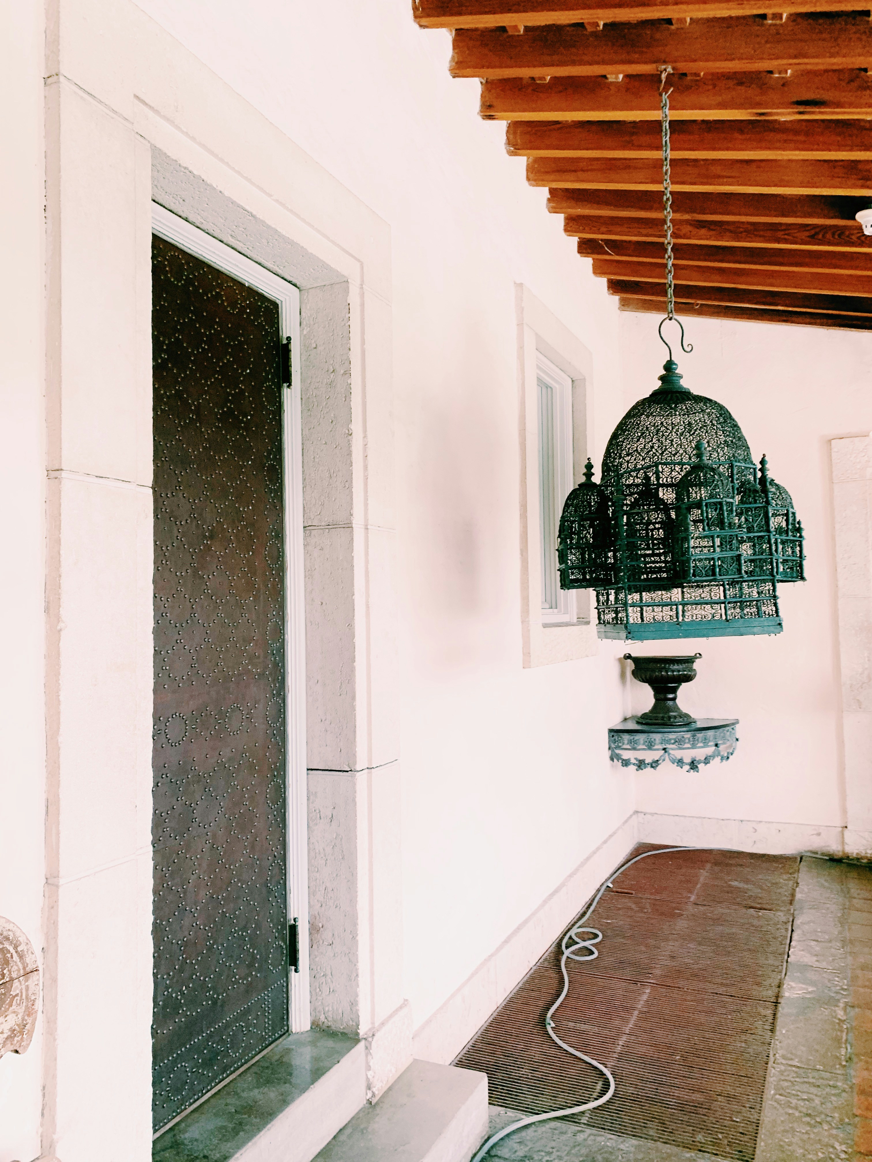 black birdcage near closed door
