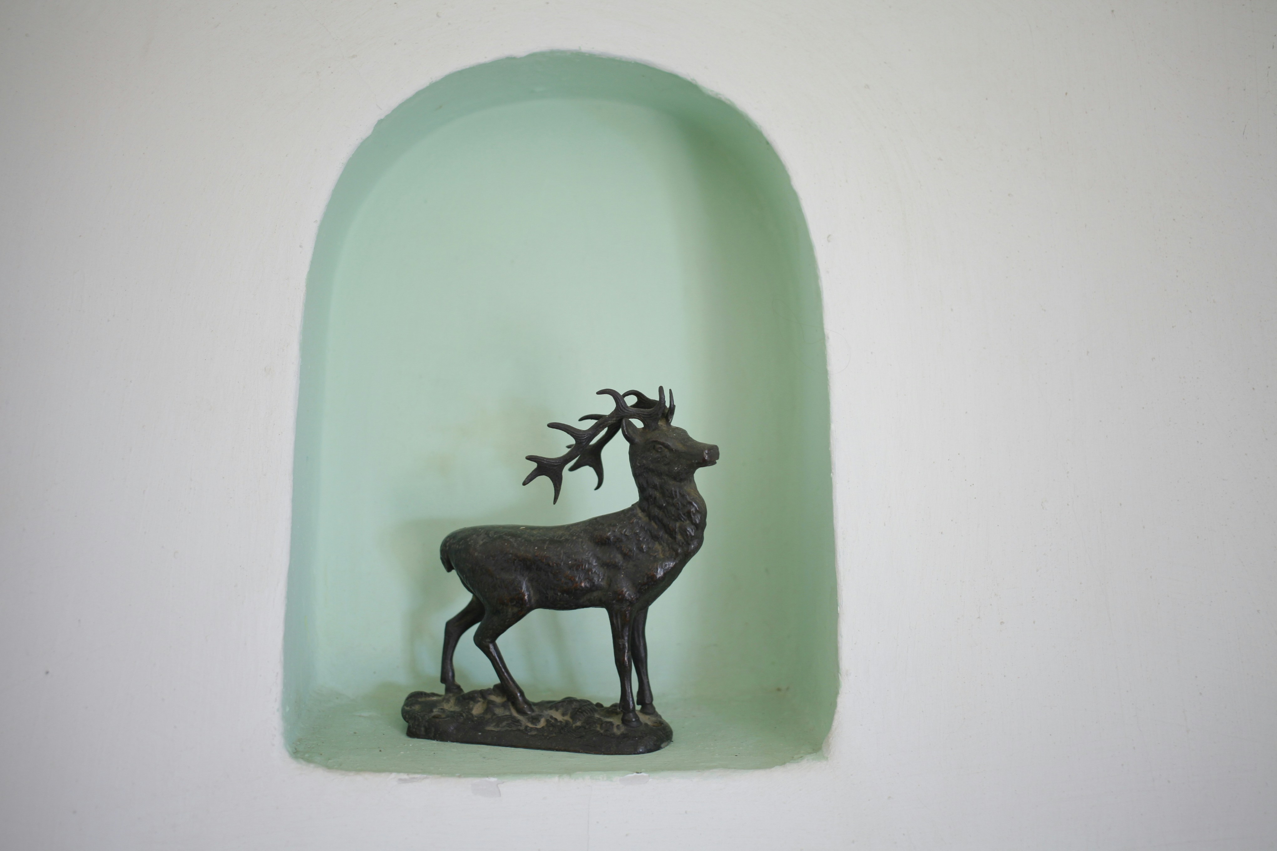 Stag in a Mint-green Niche: A Quiet Metallic Sentinel