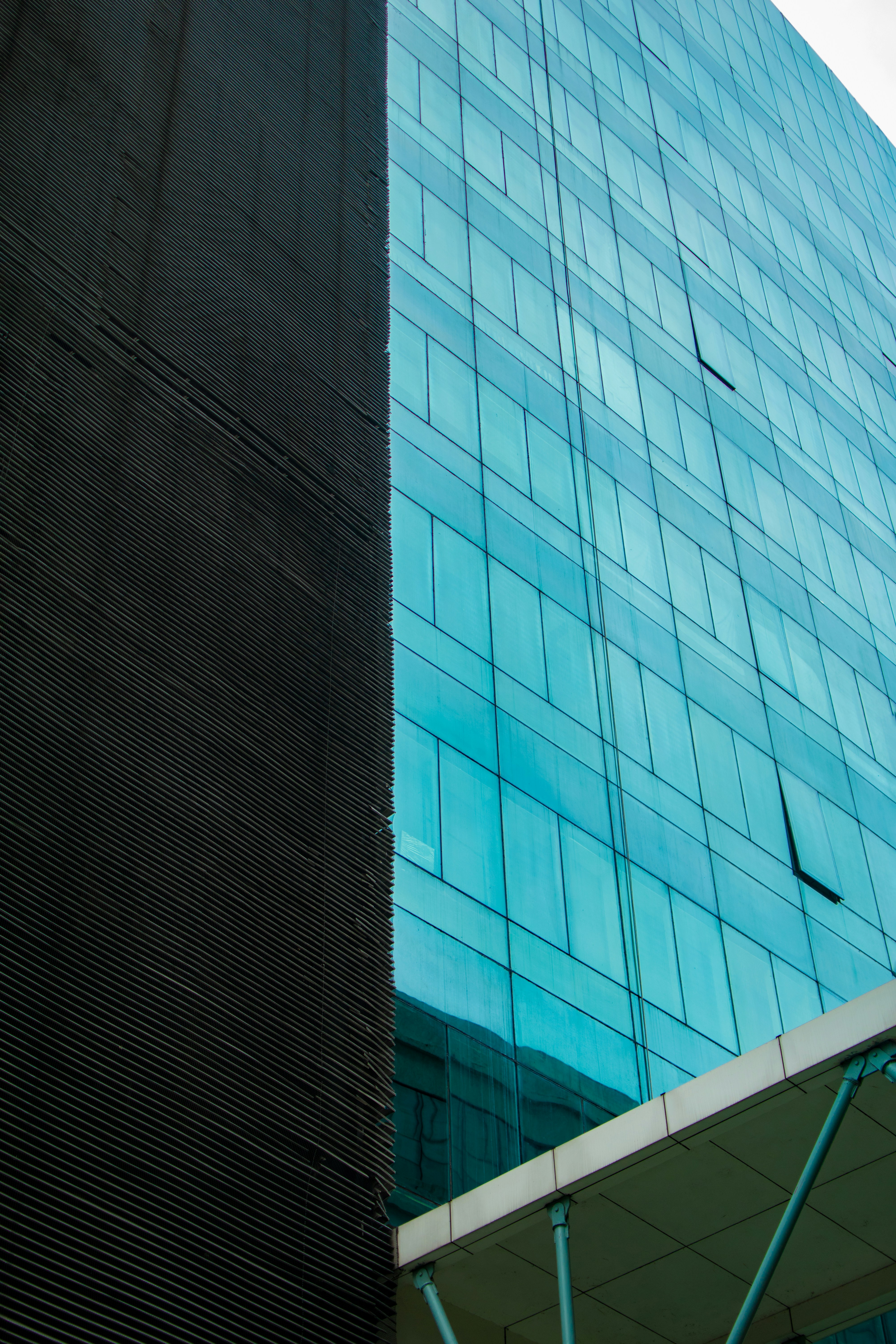 Edge of Shadow and Teal Glass: the Vertical Seam of a Modern Facade