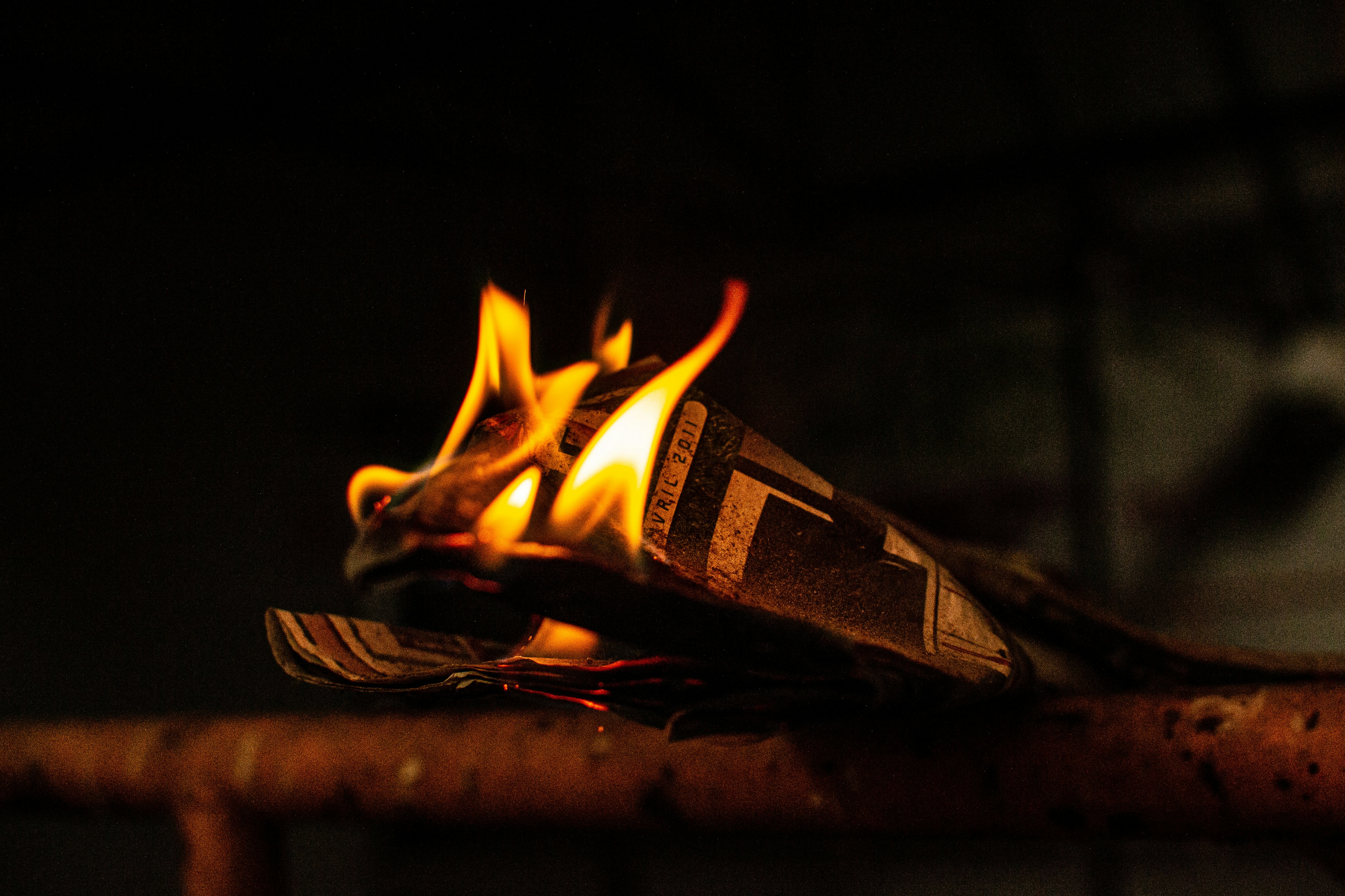 Tiny Flame Resting on a Burnt Paper Sliver
