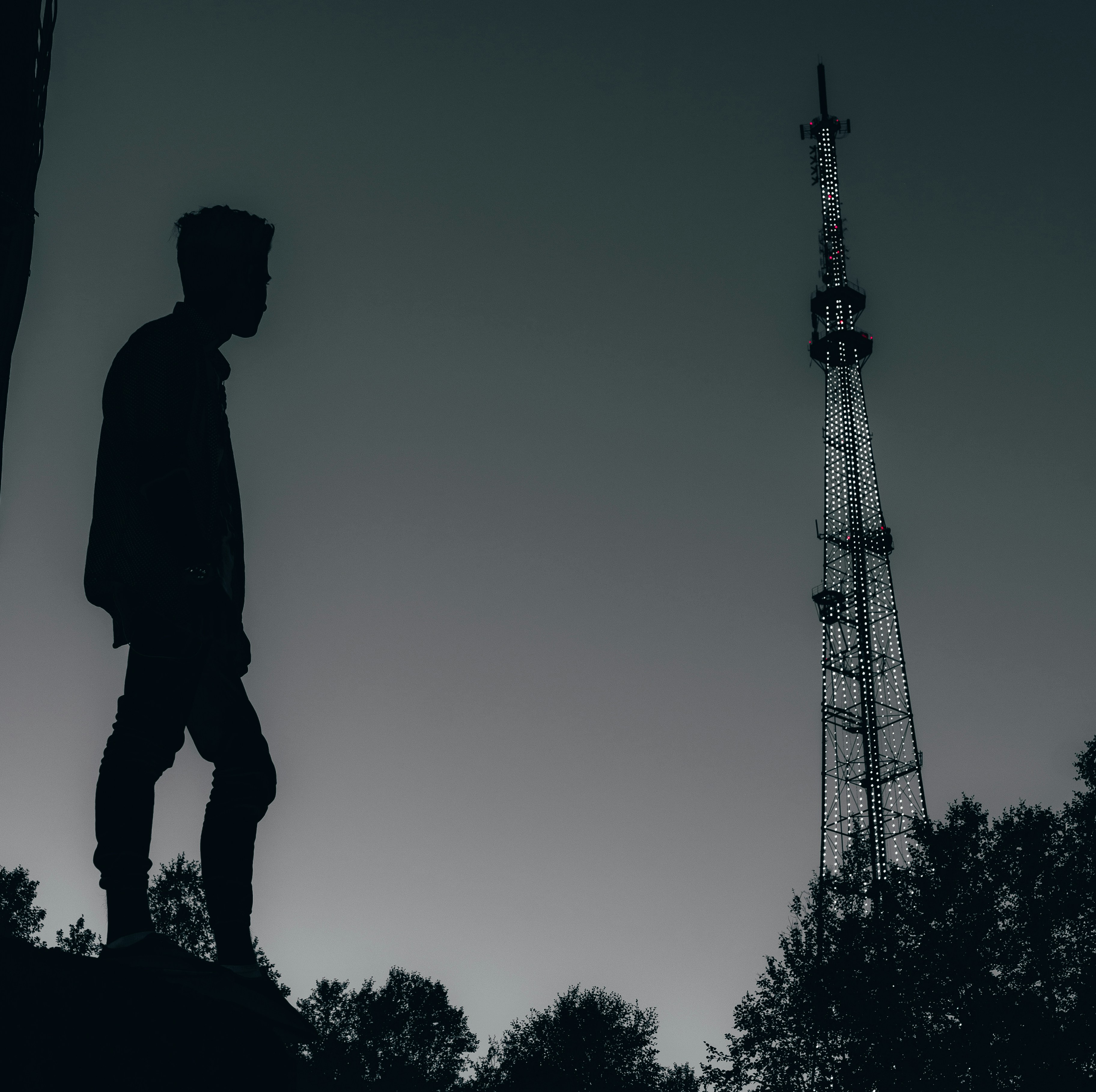 Silhouette Vigil: A Lone Figure and a Tower Against Dusk